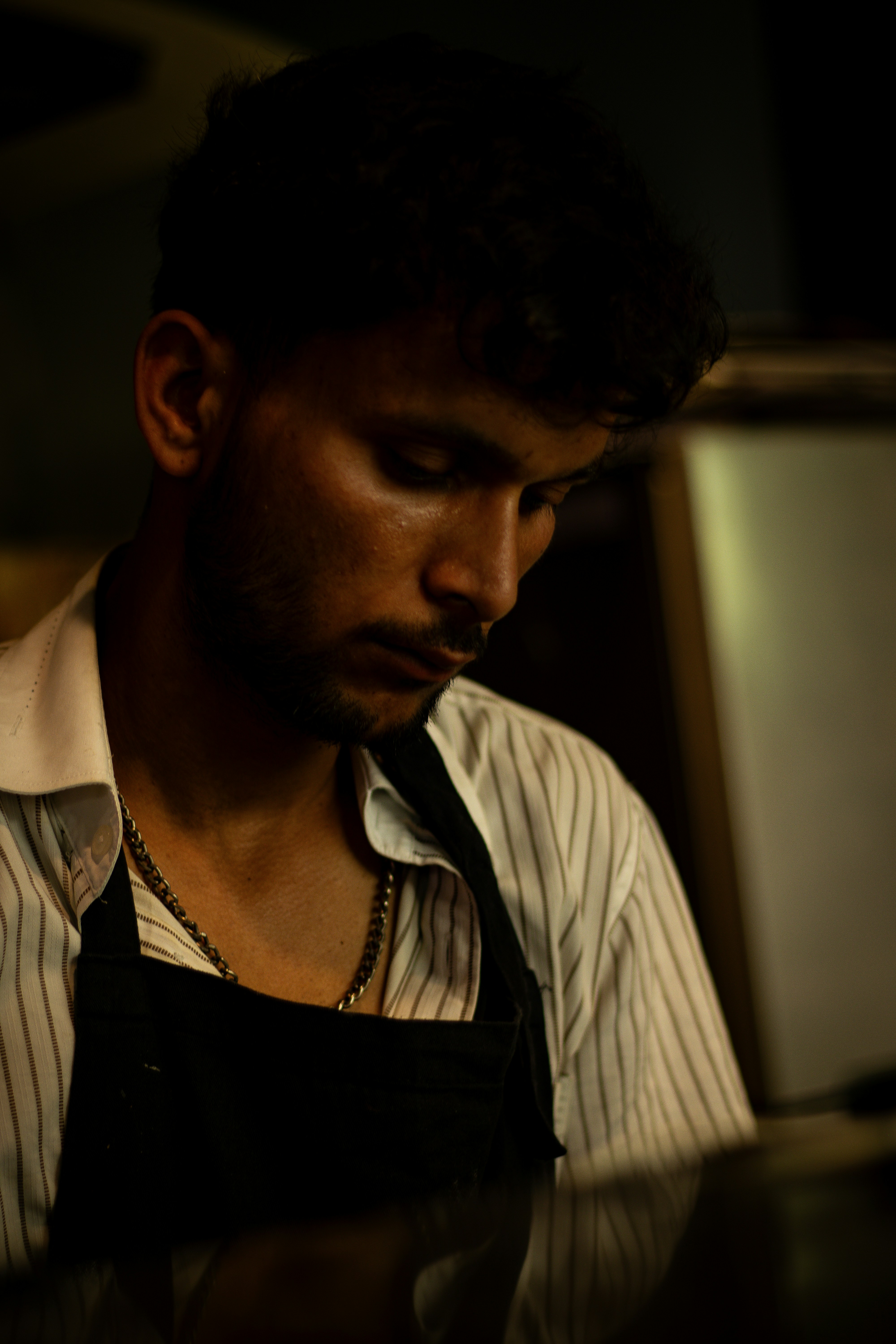 Whispers of Focus in a Dim Kitchen: A Portrait of Quiet Intent