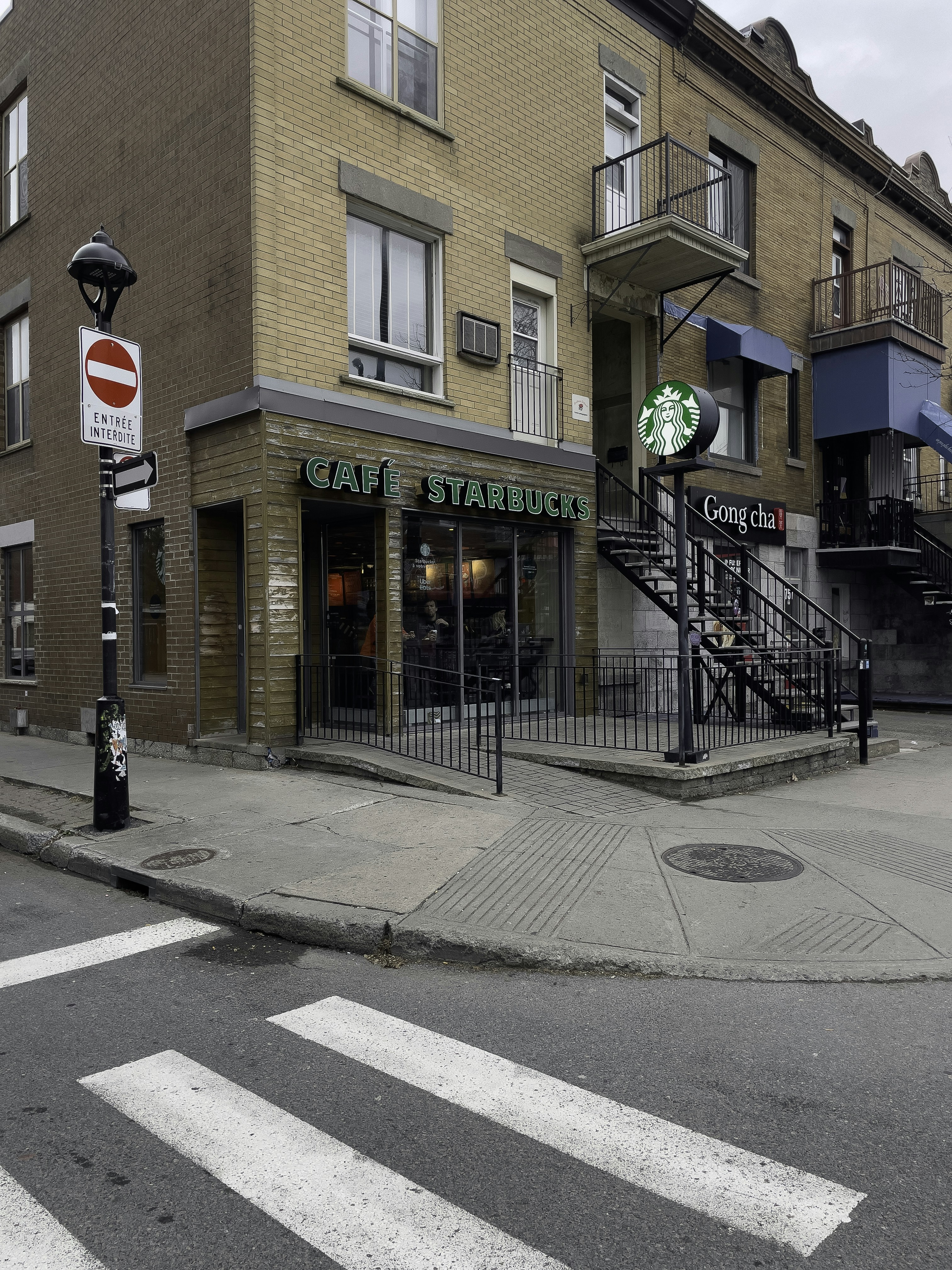 A street corner with a crosswalk and storefronts photo – Free City ...