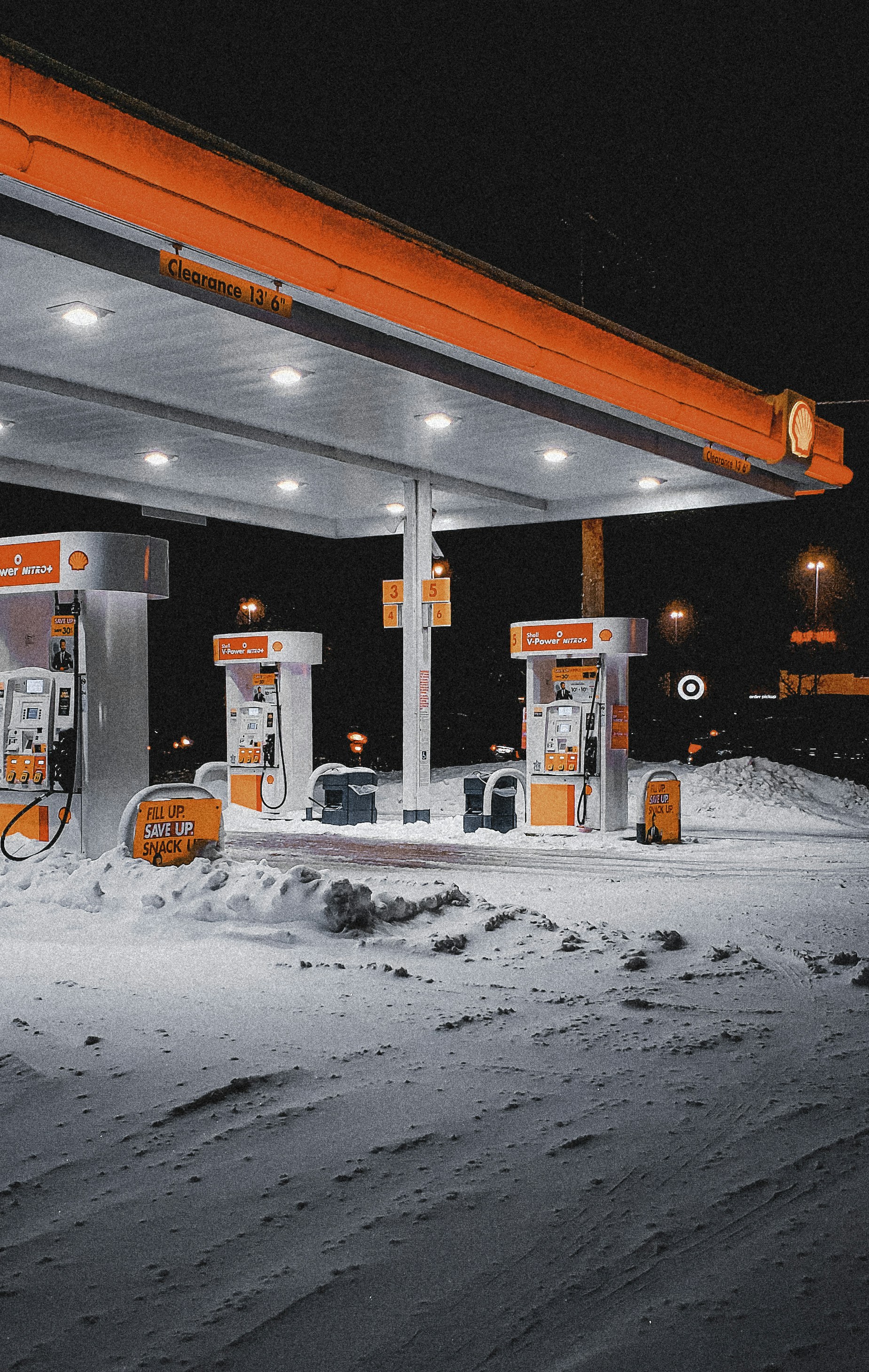 A gas station with snow on the ground photo – Free Human Image on Unsplash