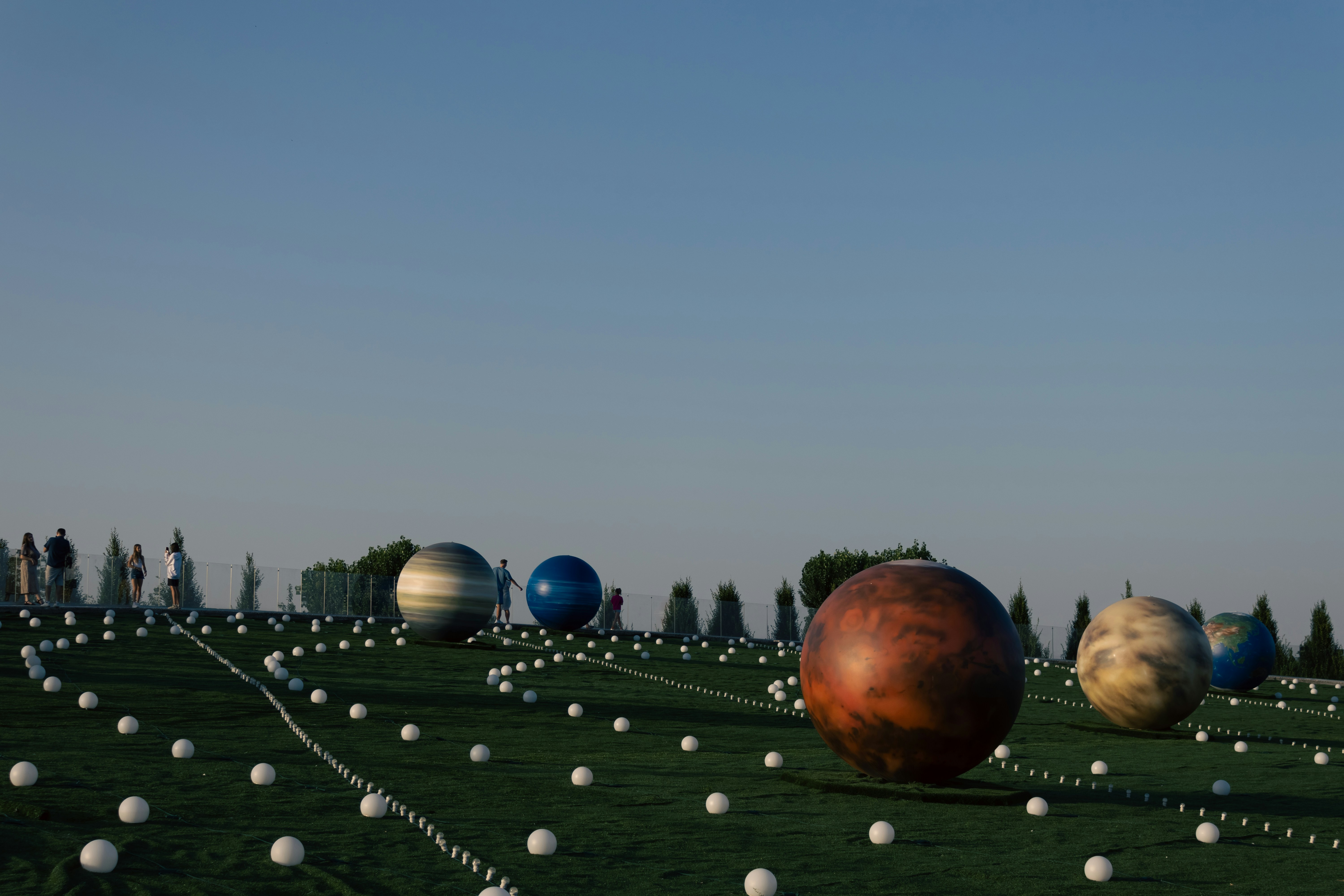 Planetary Orbs on the Green: A Sunlit Field of Sculptural Spheres and Grids