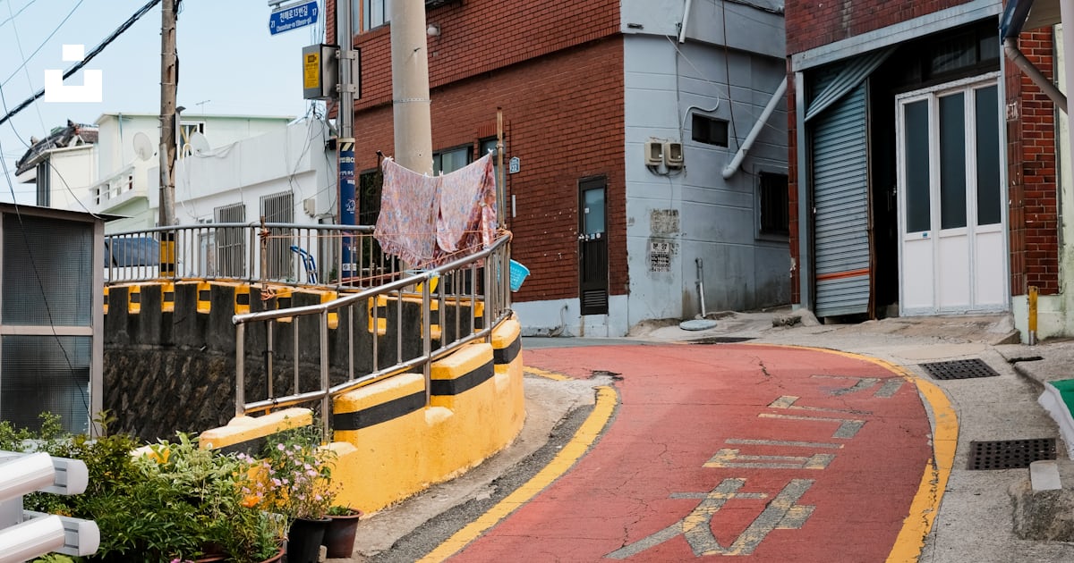 빨간색과 노란색으로 칠해진 거리를 배경으로 건물이 있습니다 사진 Unsplash의 무료 부산 이미지