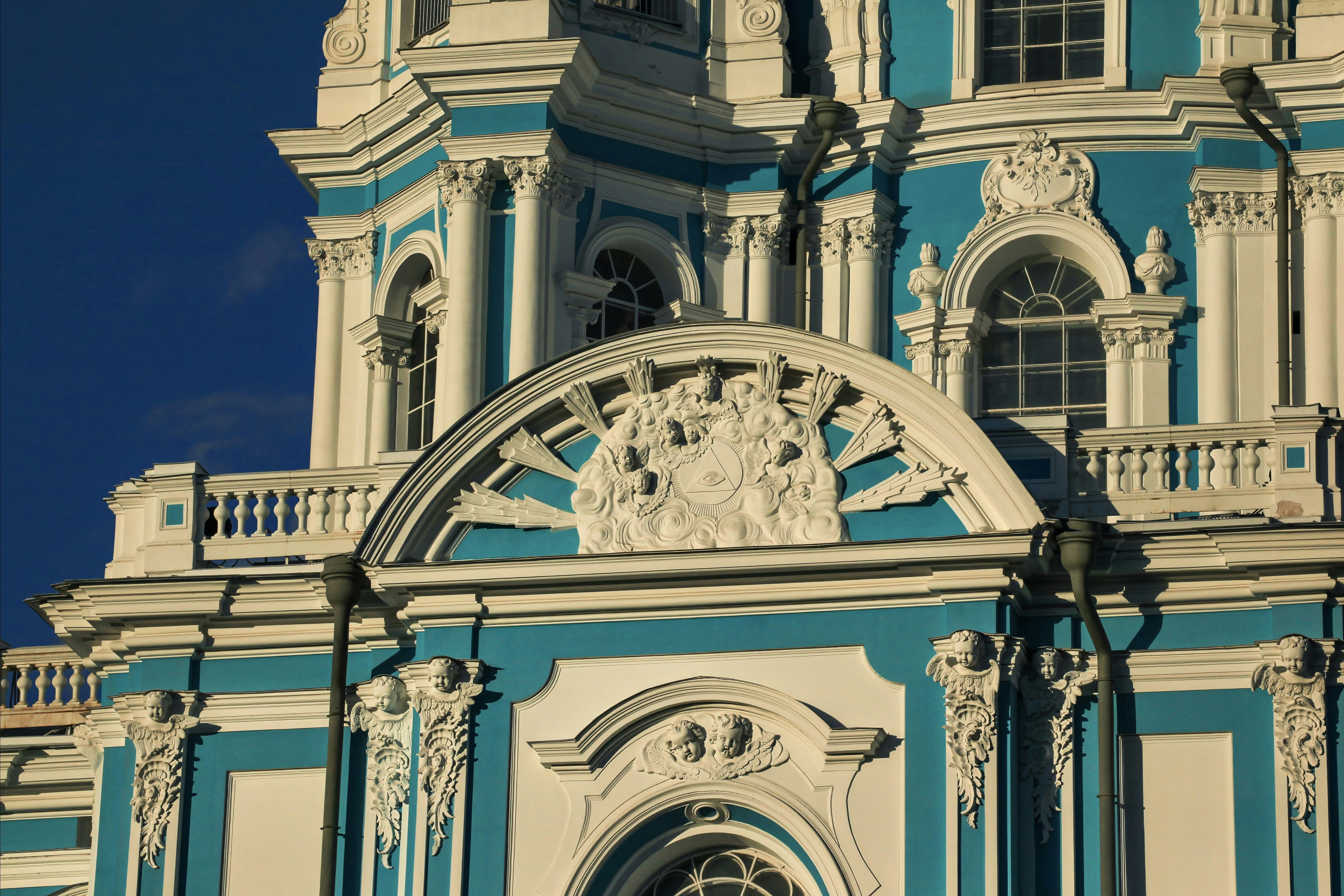 Baroque architecture with intricate detailing and a prominent clock tower against a blue sky.