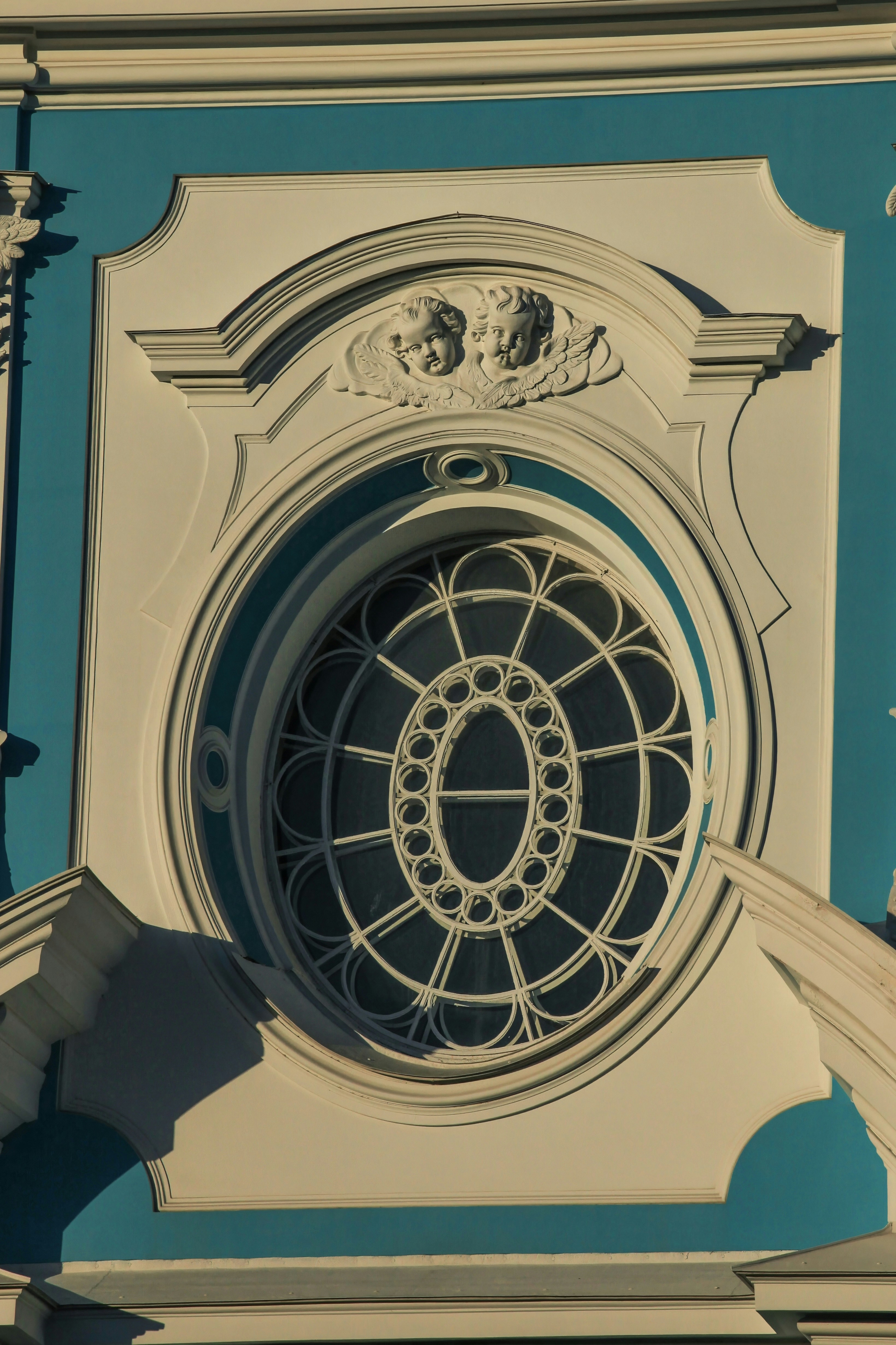 Rosette on Turquoise: Sunlit Circular Window Framed in Cream
