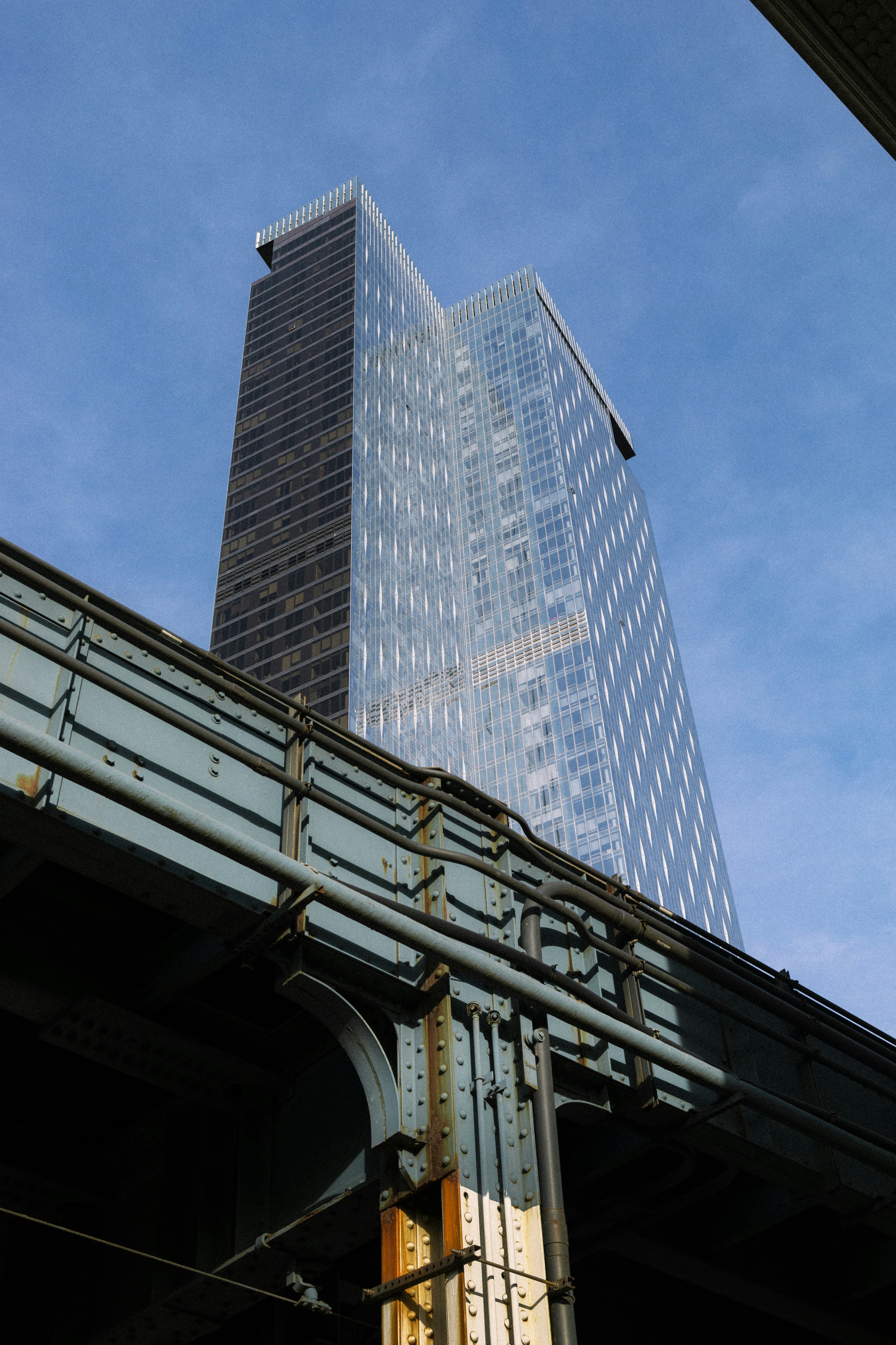 A tall building towering over a city next to a bridge photo – Free New ...