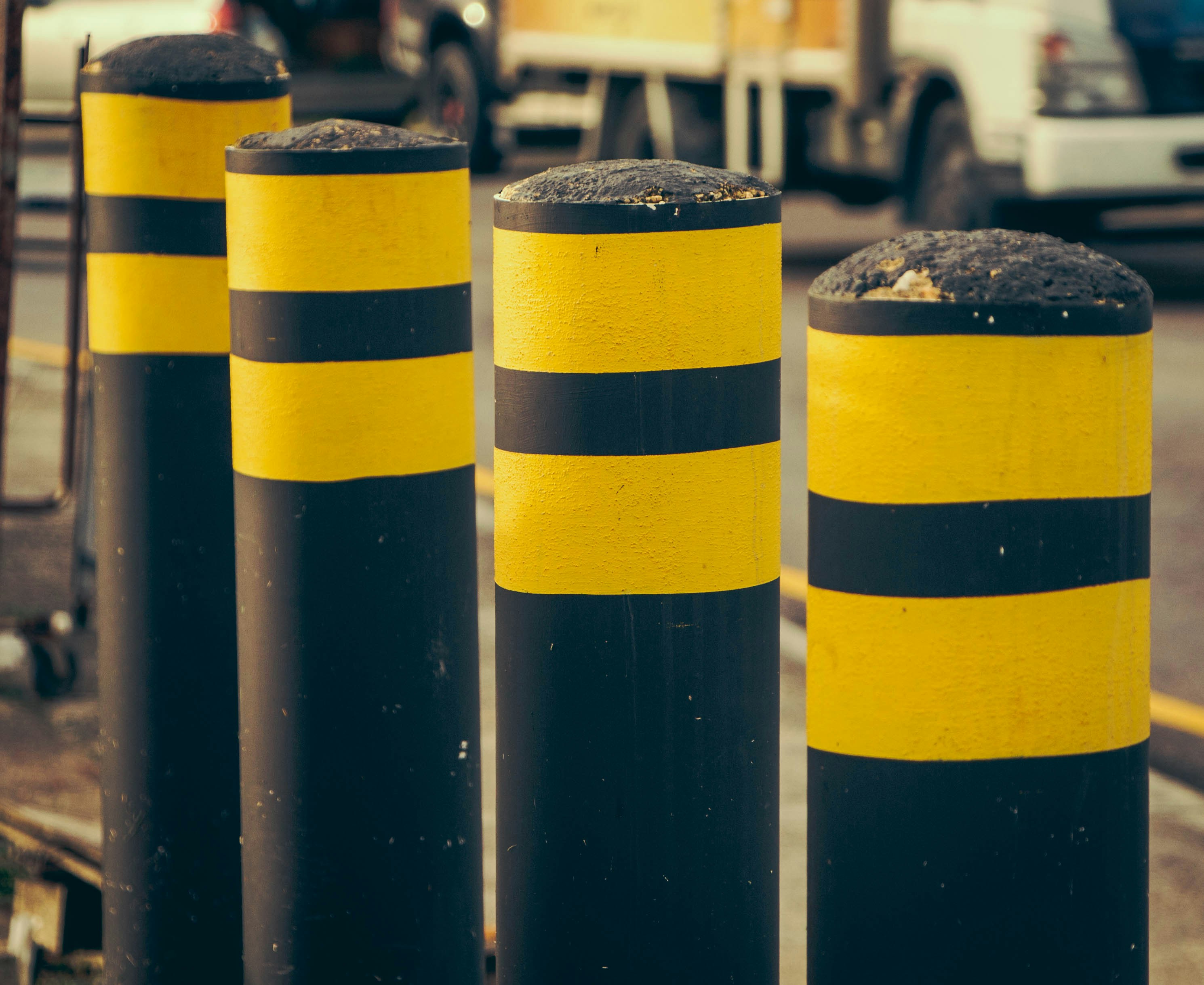 A group of black and yellow poles sitting on the side of a road photo ...