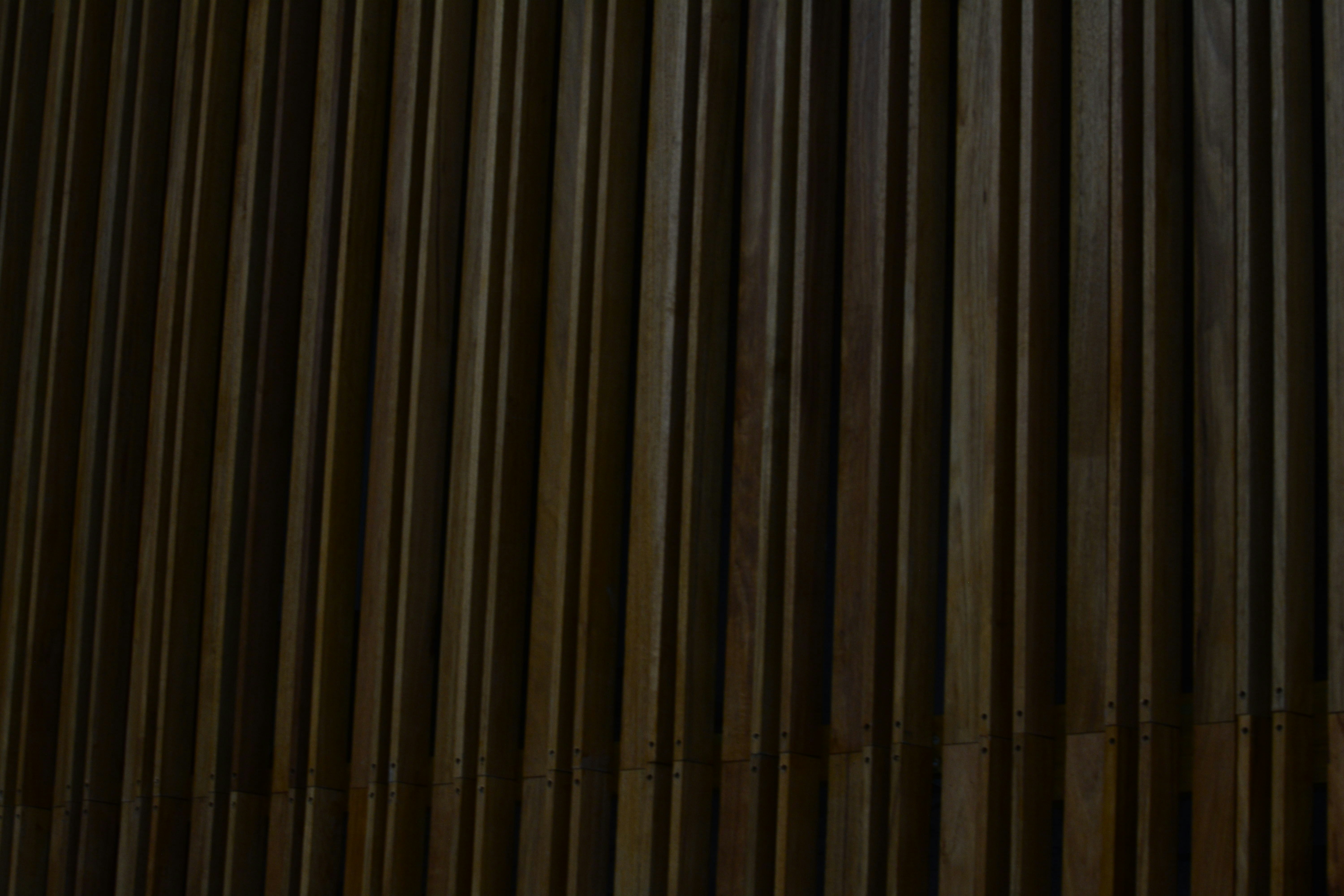 A man in a suit and tie standing in front of a wooden wall