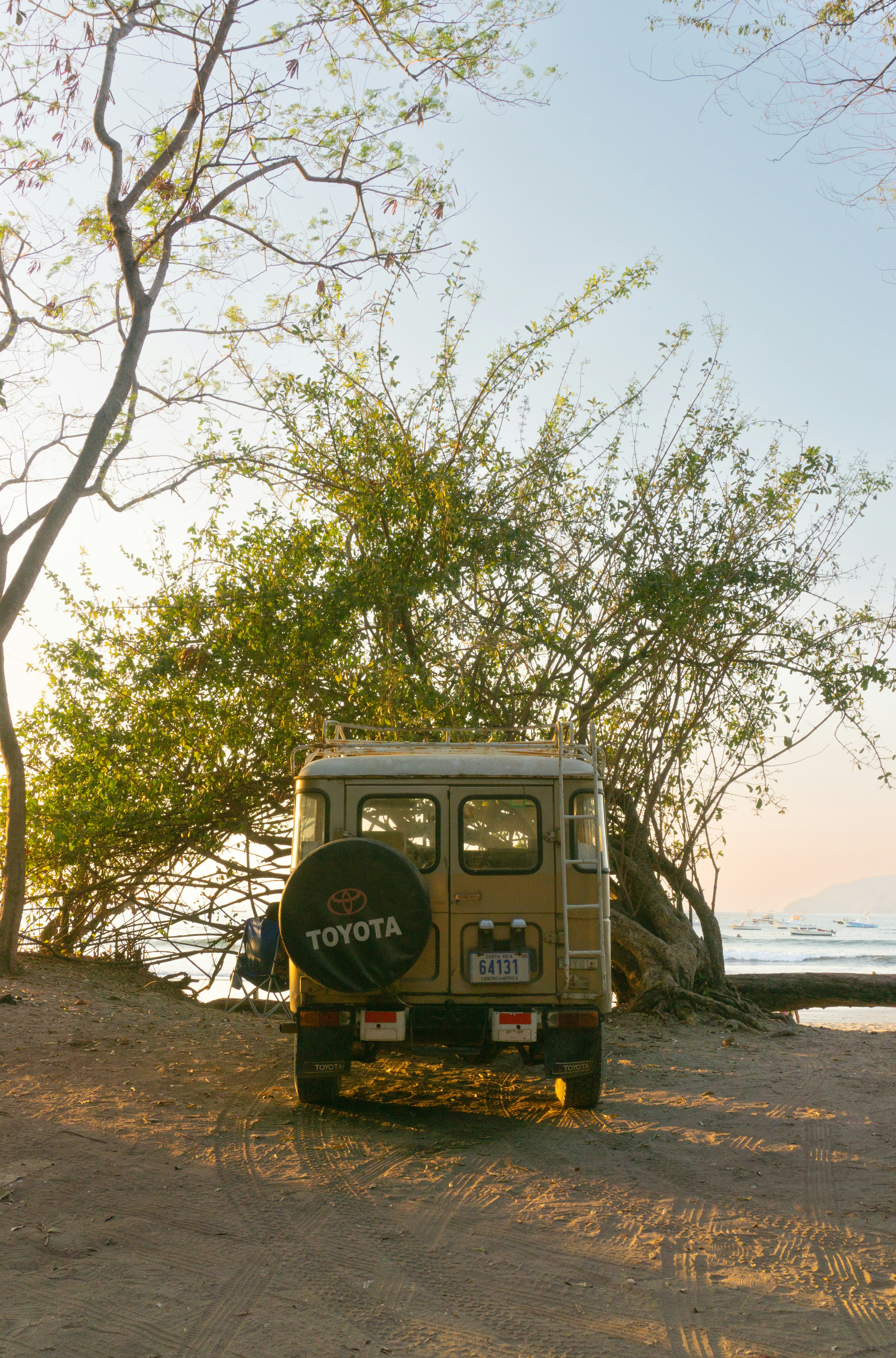 Toyota on the Shore: A Weathered SUV Guarding the Tree-Line at Golden Hour
