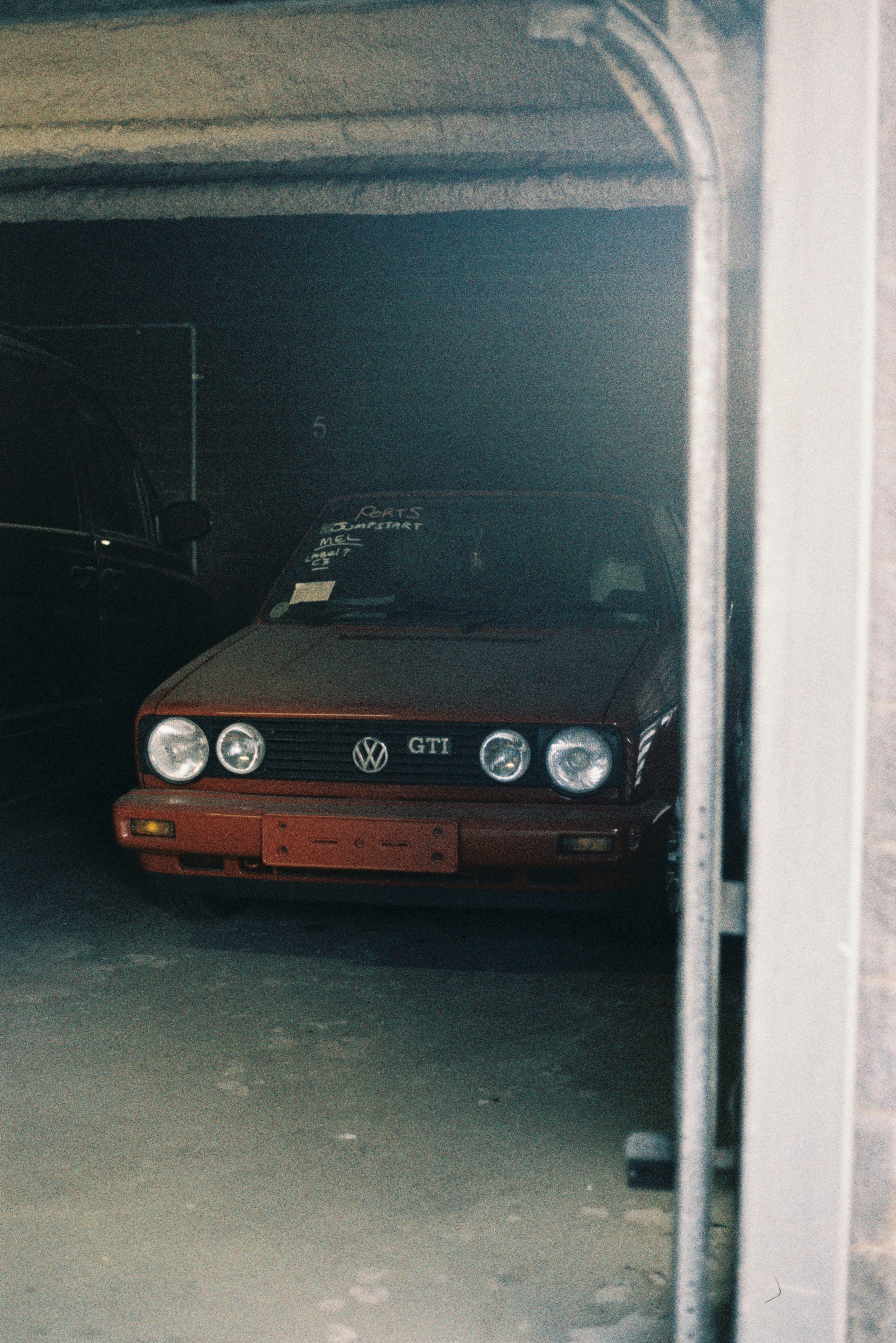 VW GTI Emerges from Shadows: Front-Face in a Dim Garage