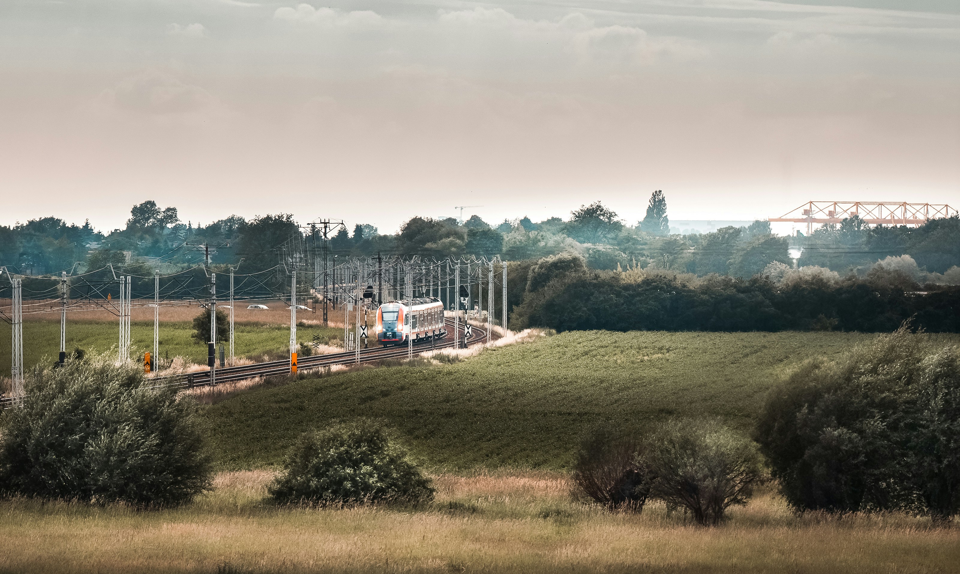 A large field with a train on the tracks photo – Free City Image on ...