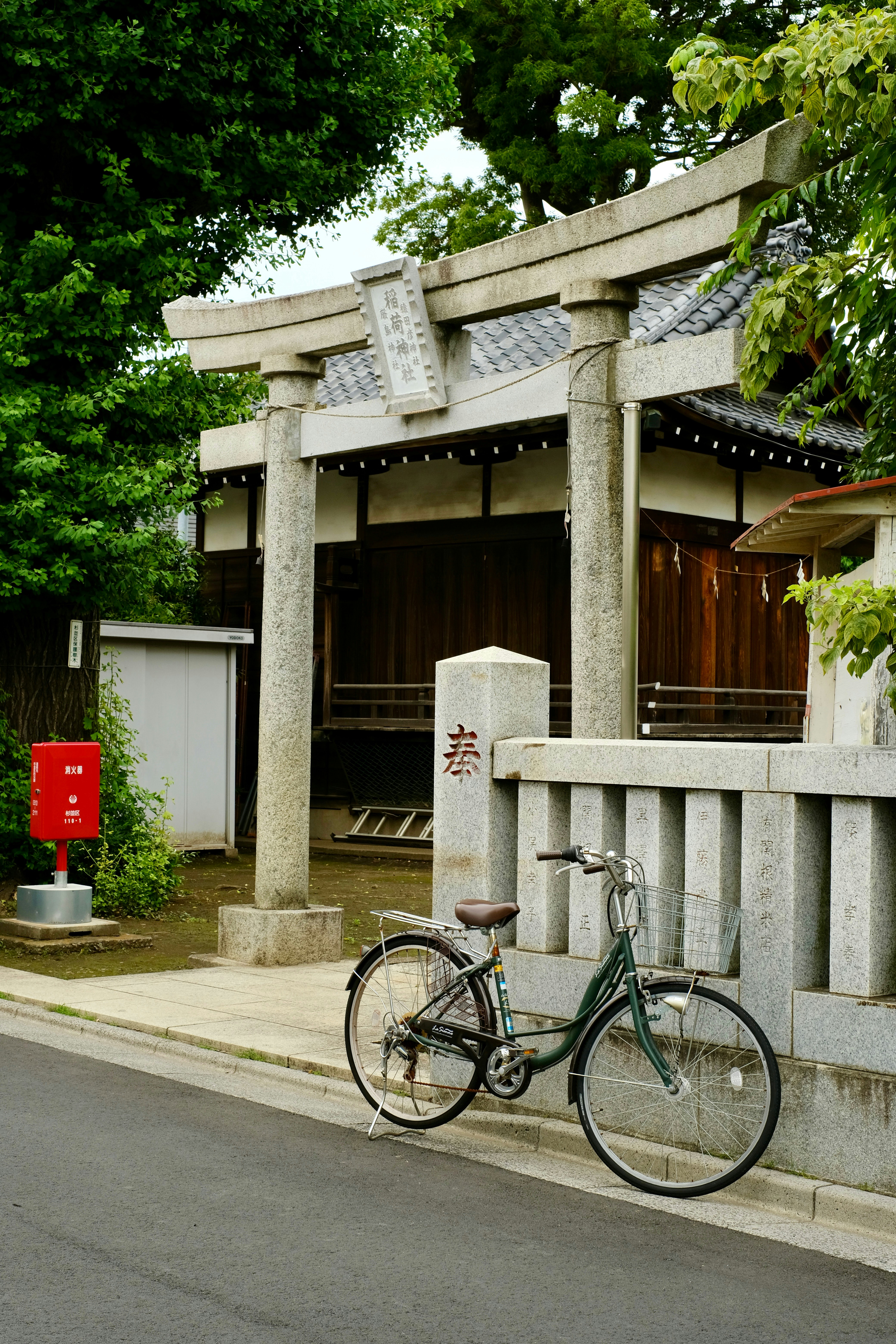 Wheels and Shrine: A Quiet Street Portrait