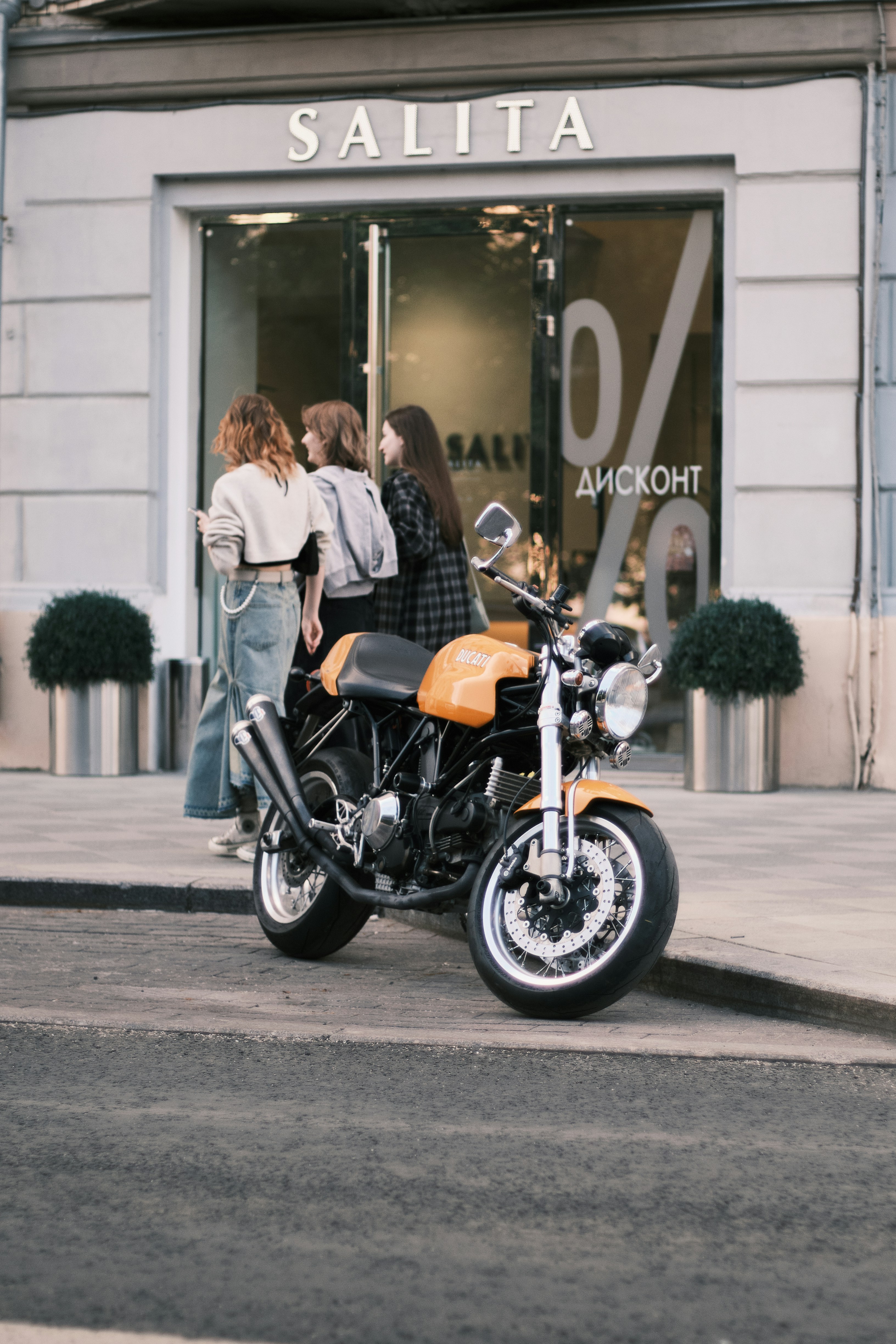 Amber Dynamo by Salita: a motorcycle paused before a fashion-forward storefront.