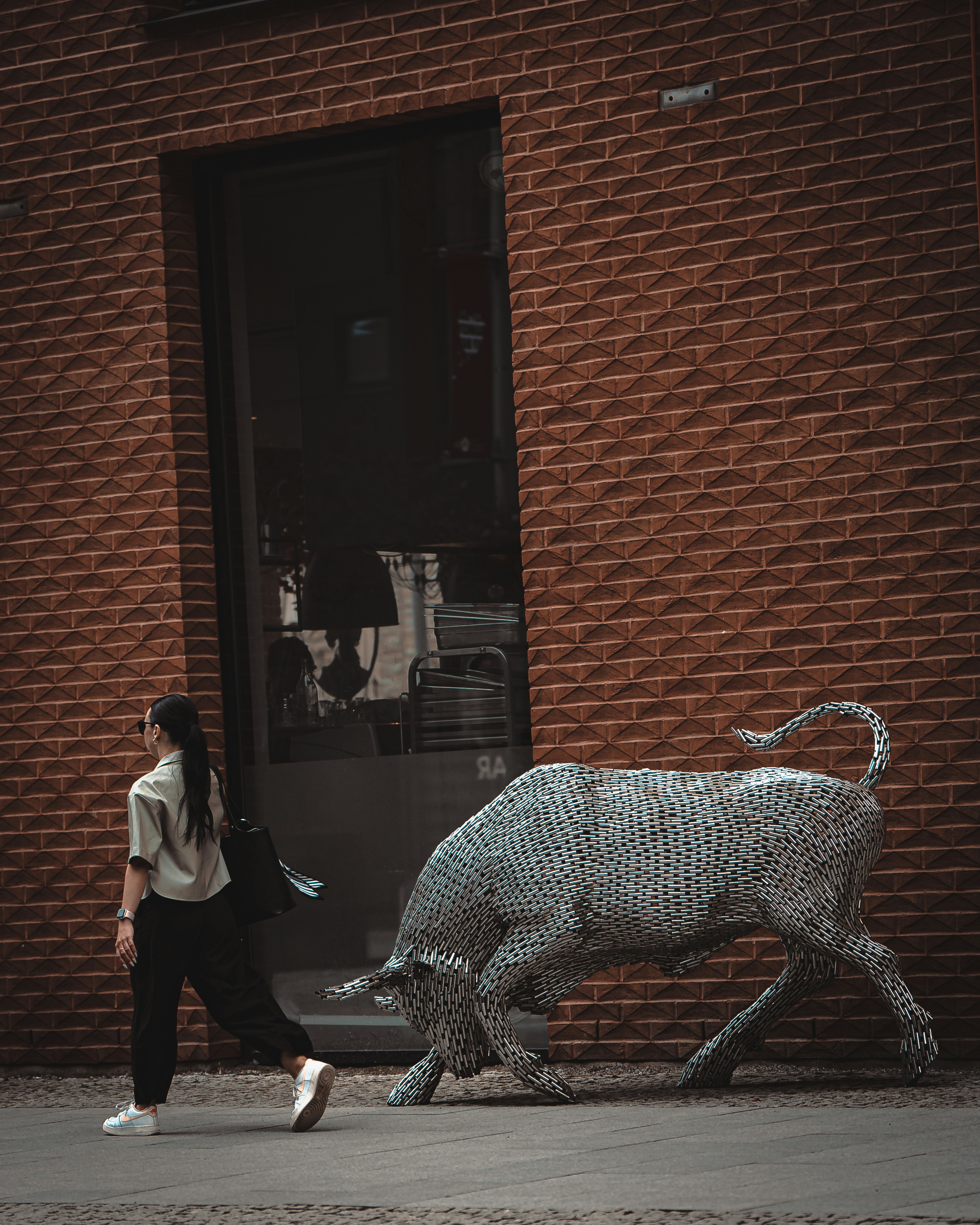 Mesh-Wire Canine in Full Sprint Against a Red Brick Backdrop