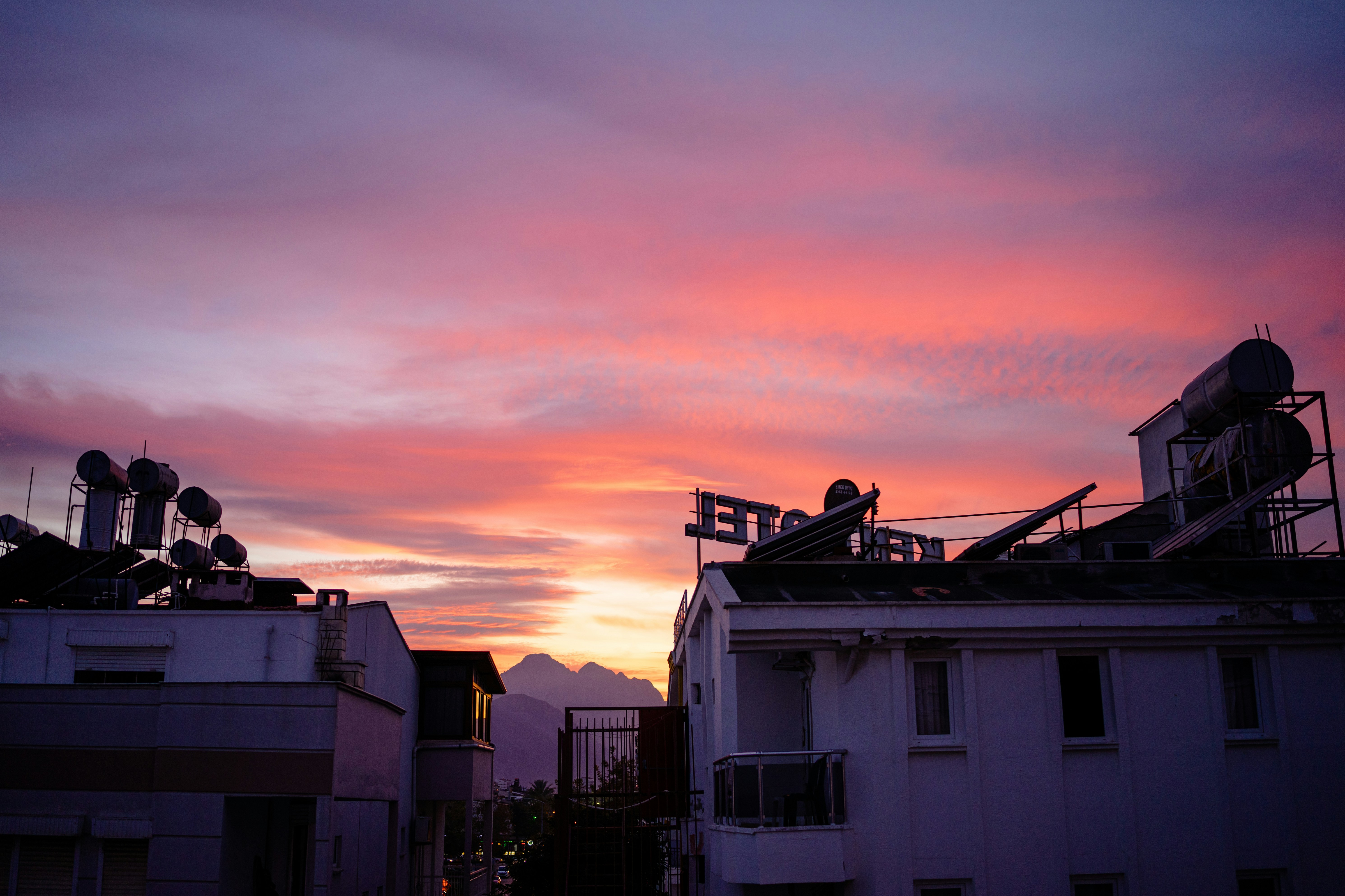 Sunset on the Rooftop Skyline Over Quiet Lull Between Hills