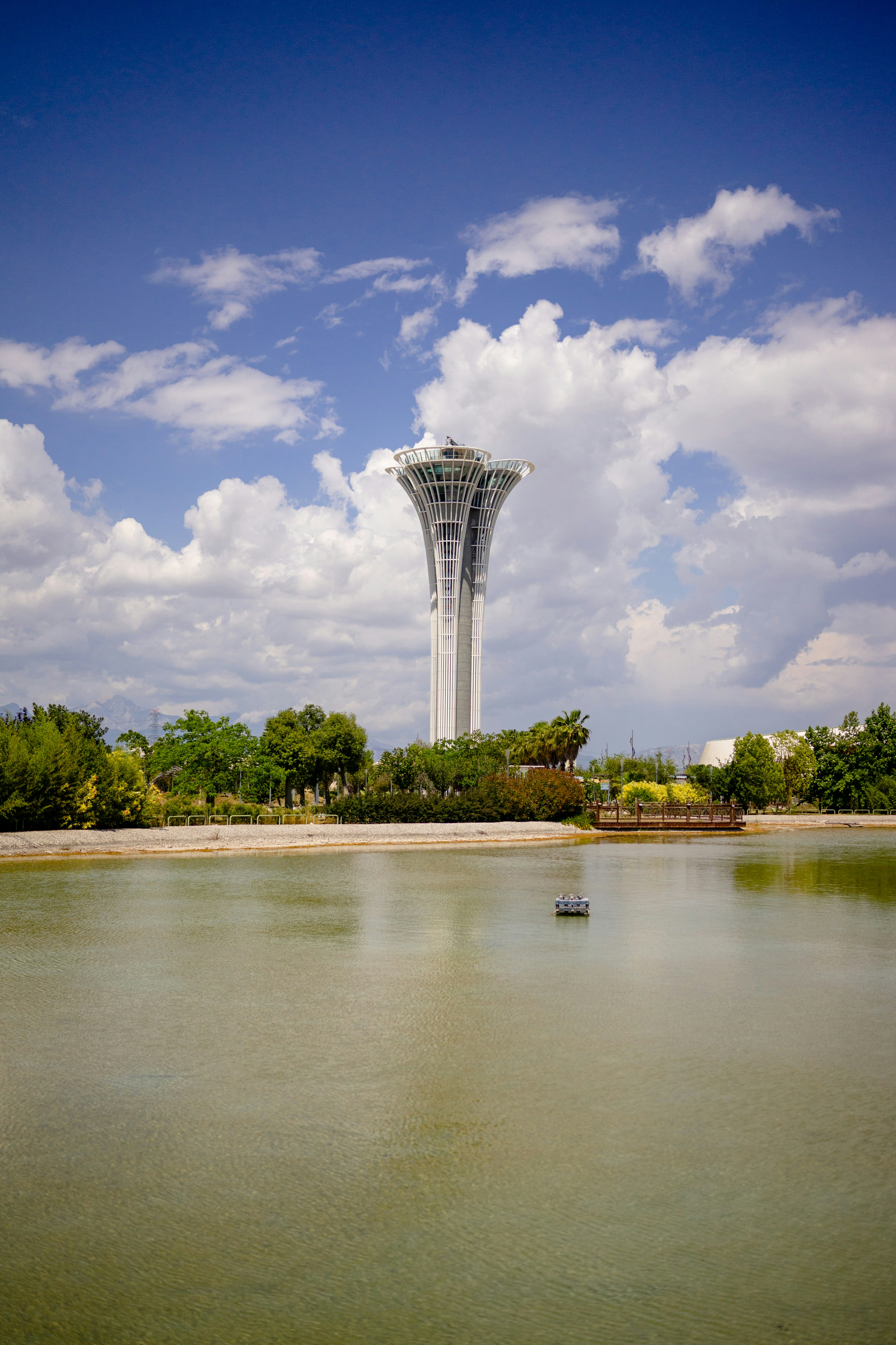 Skyward Sentinel by the River: A Modern Tower Looms Over a Quiet Park