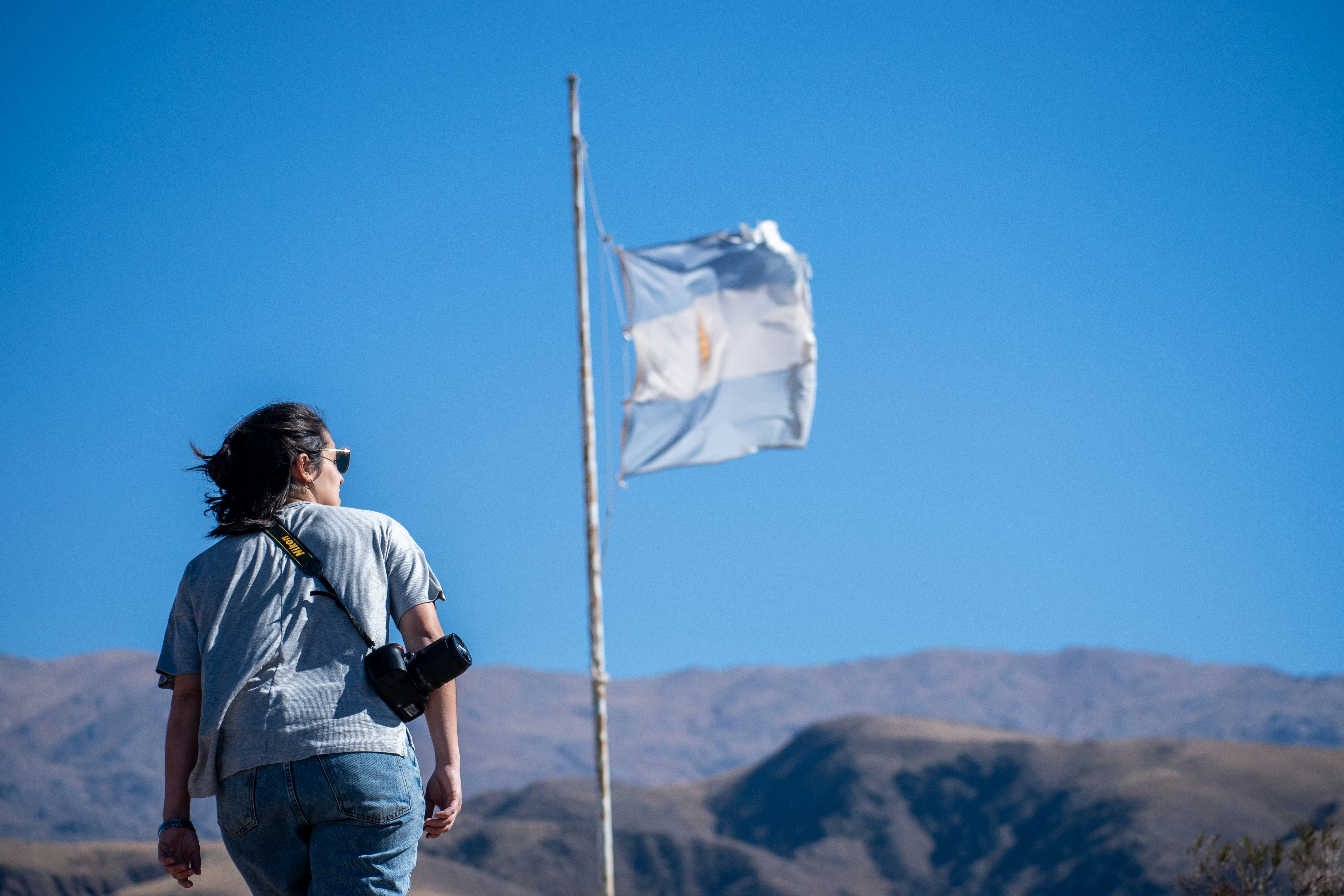 Flag of the Wind: A Person and a Distant Emblem against Open Skies
