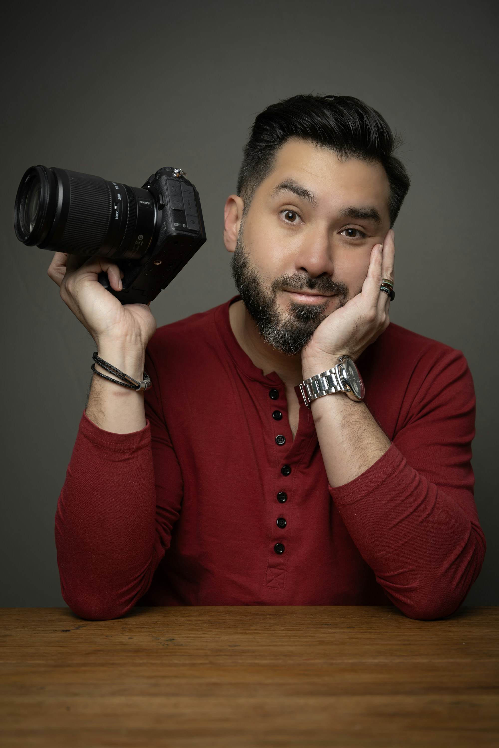 A man sitting at a table with a camera photo – Free Headshot Image on ...