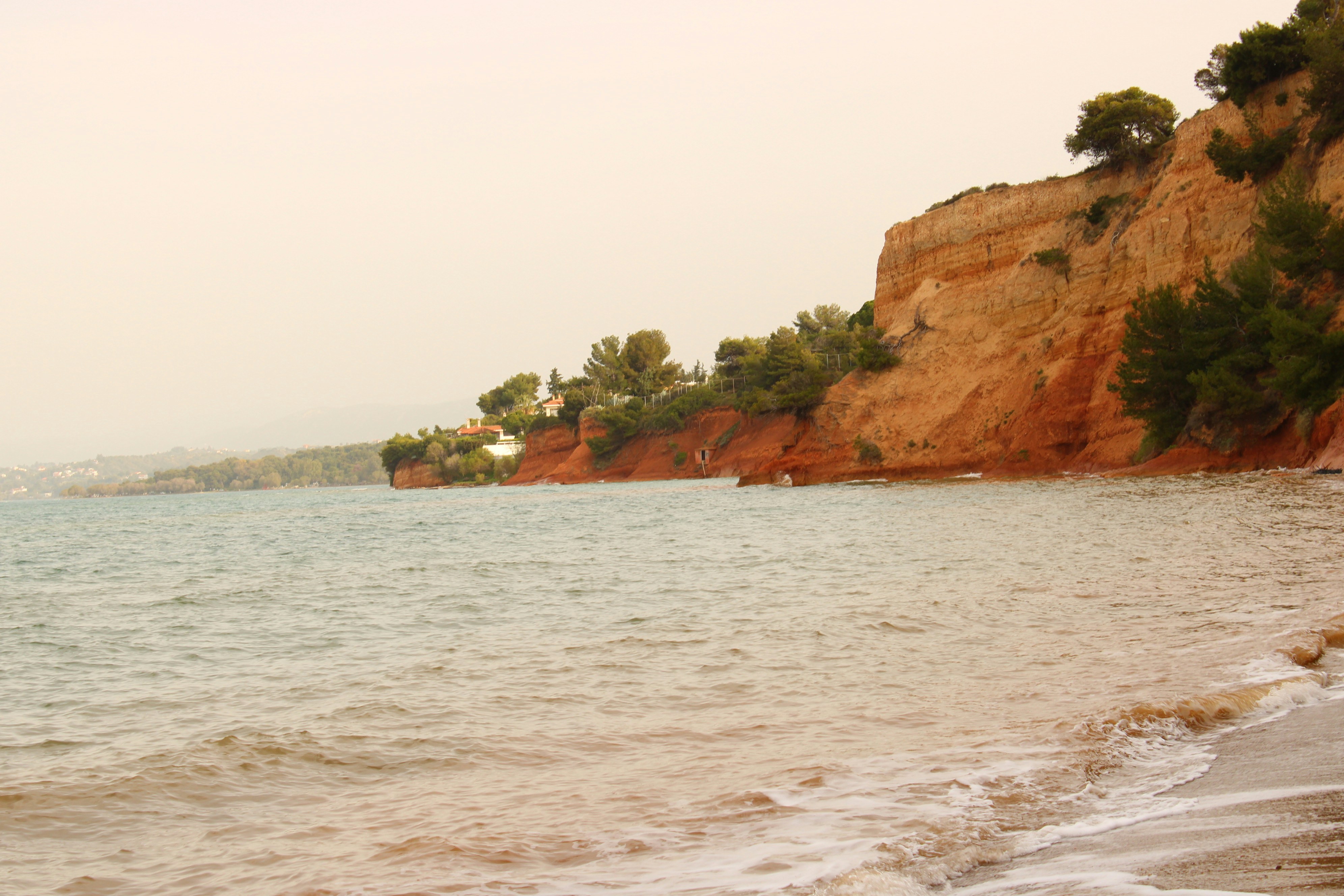Crimson Cliffs Framing a Quiet Coastal Sea at Dusk