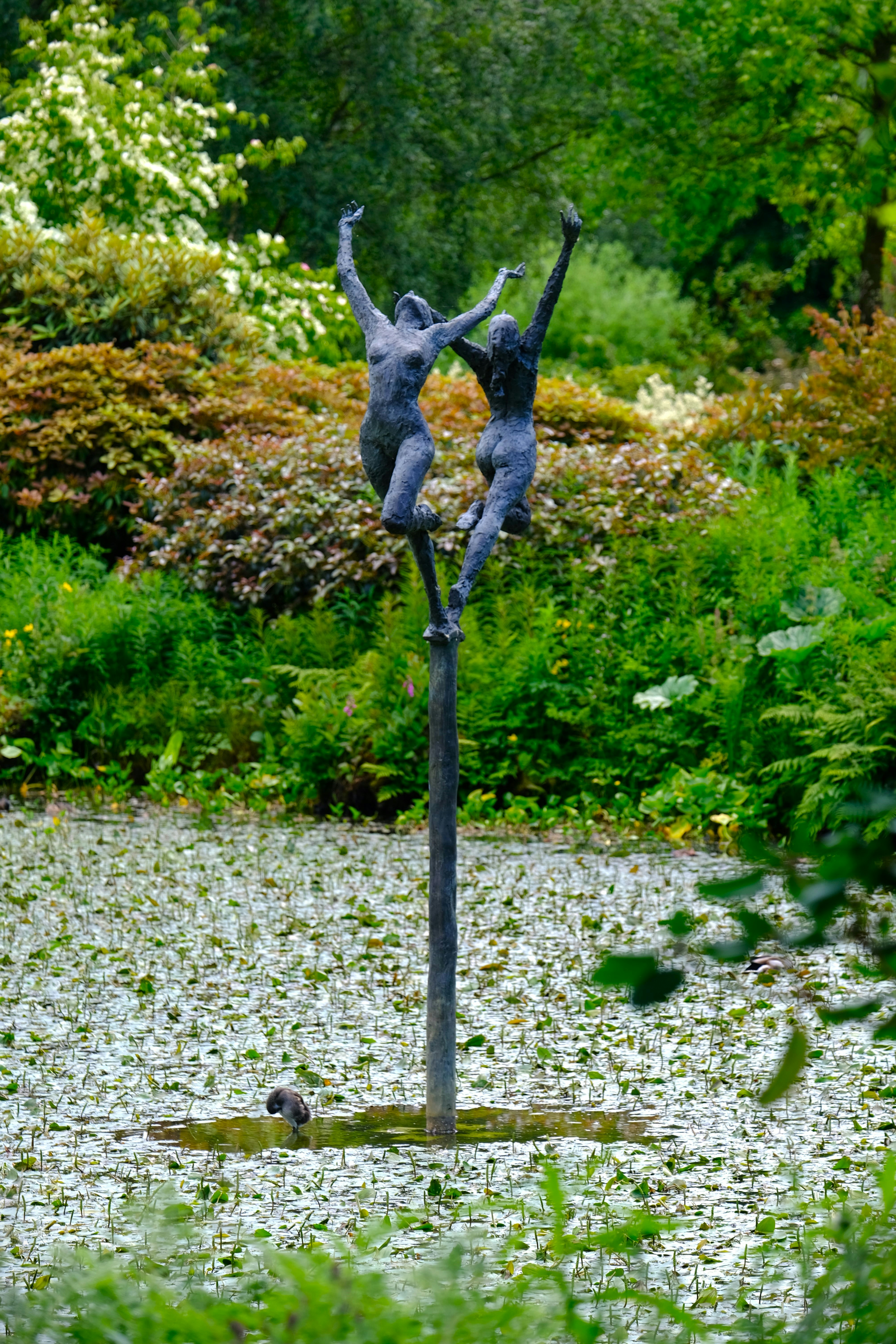 Twin Figures Above the Pond: A Garden Bronze Sculpture Reaching for Sky