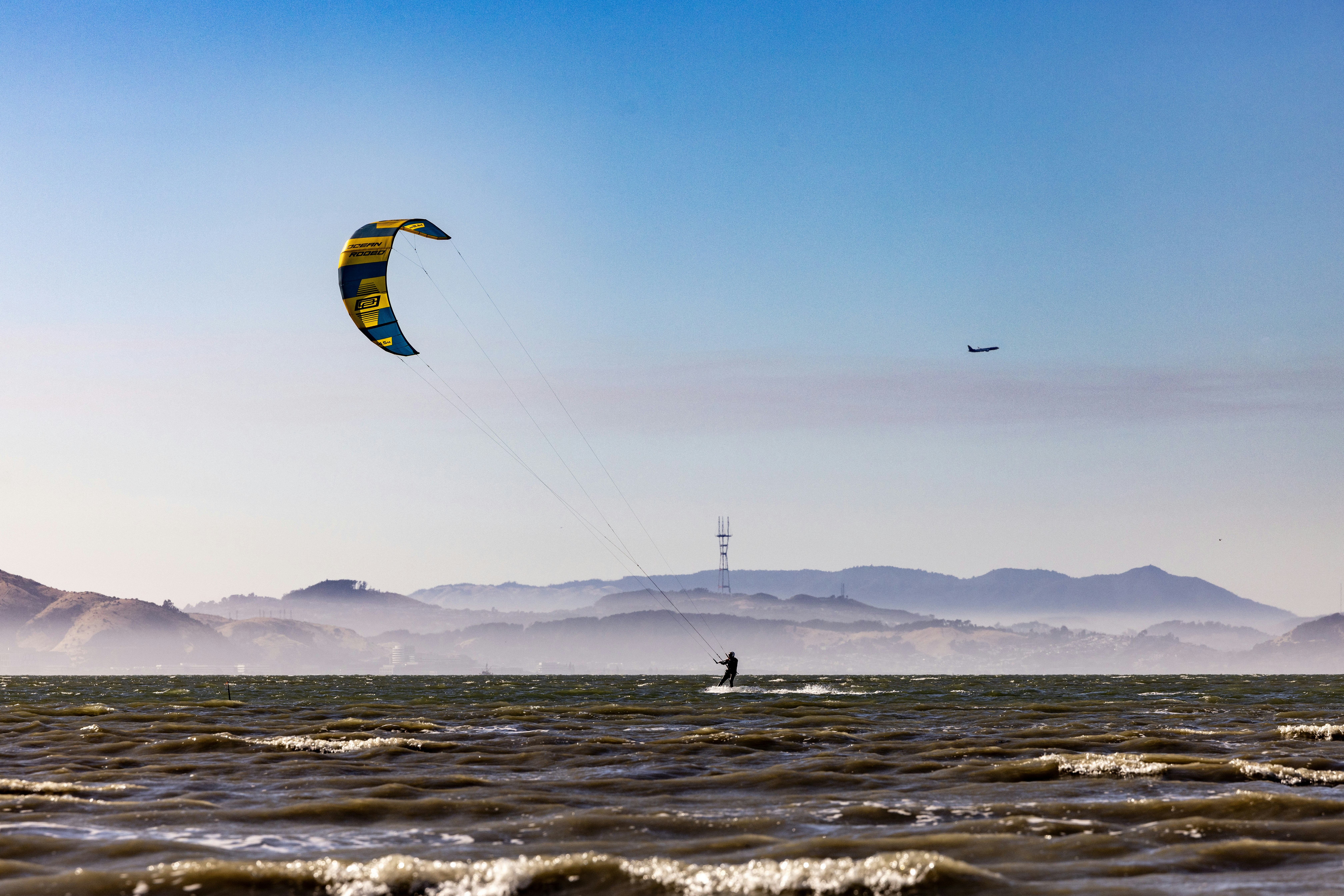 Arc of Wind Over Dawn-Blue Seas: Kite Surfer Against a Quiet Horizon