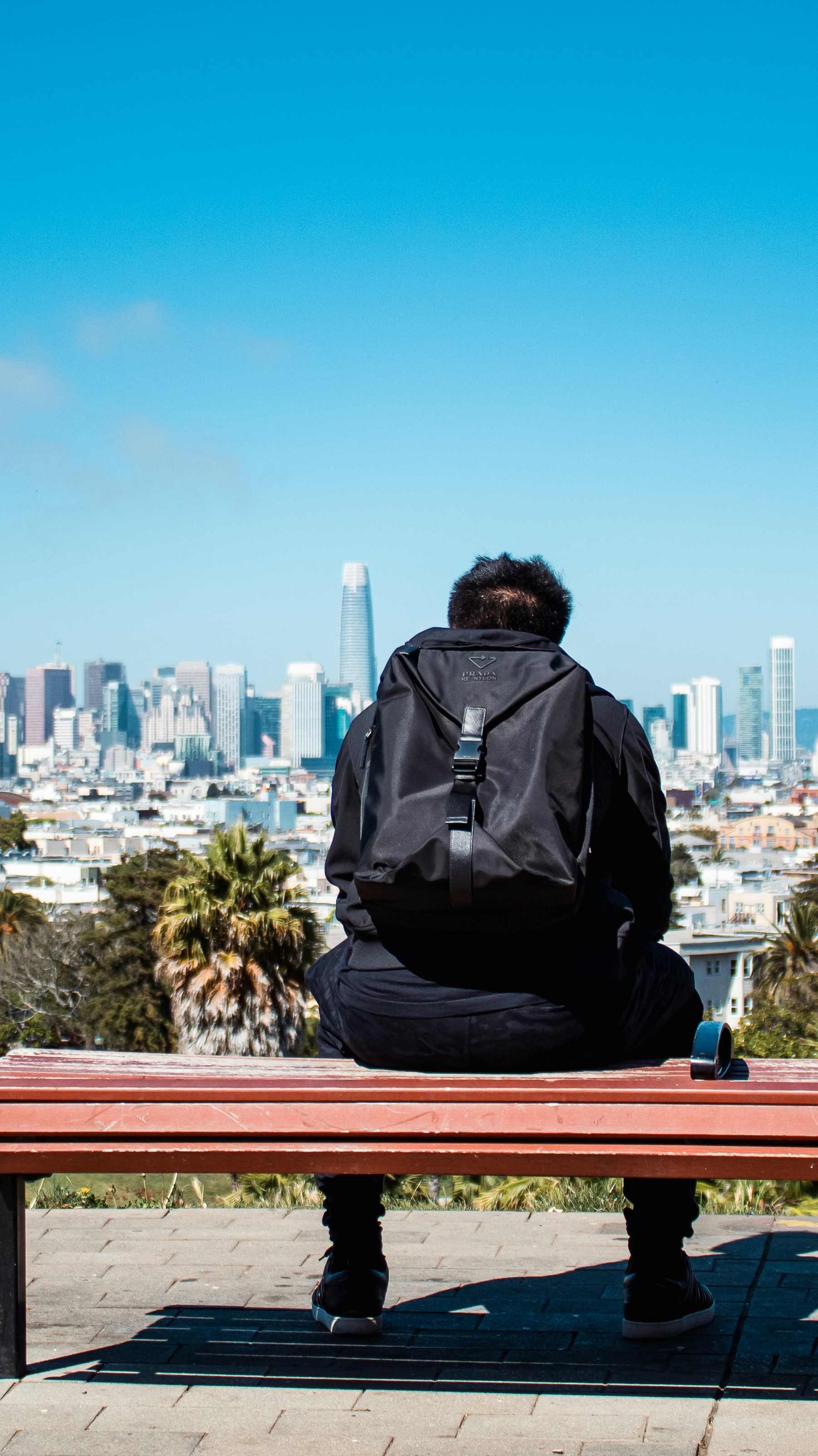 Backlit Horizon: A lone rider gazes toward the cityscape