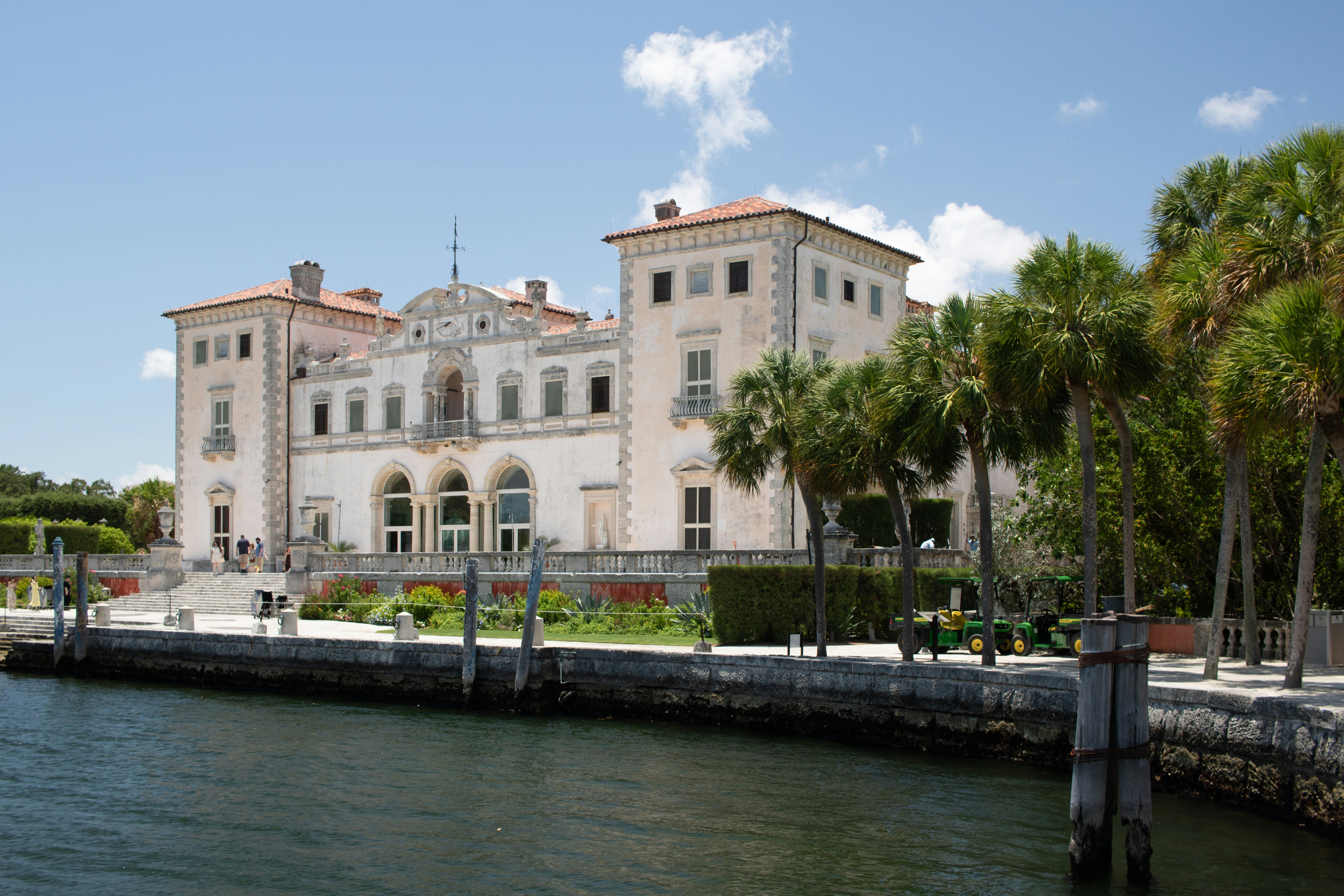 The Vizcaya Museum and Gardens, located in the Coconut Grove neighborhood of Miami, Florida, is an exquisite example of Mediterranean Revival architecture infused with Italian Renaissance influences. Built between 1914 and 1922 as the winter residence of industrialist James Deering, Vizcaya encompasses 34 decorated rooms filled with European antiques and art dating from the 16th to the 19th centuries. The estate originally spanned 180 acres, although today it covers approximately 50 acres, with 10 acres of formal gardens, extensive native woodlands, & a historic village outbuildings compound.