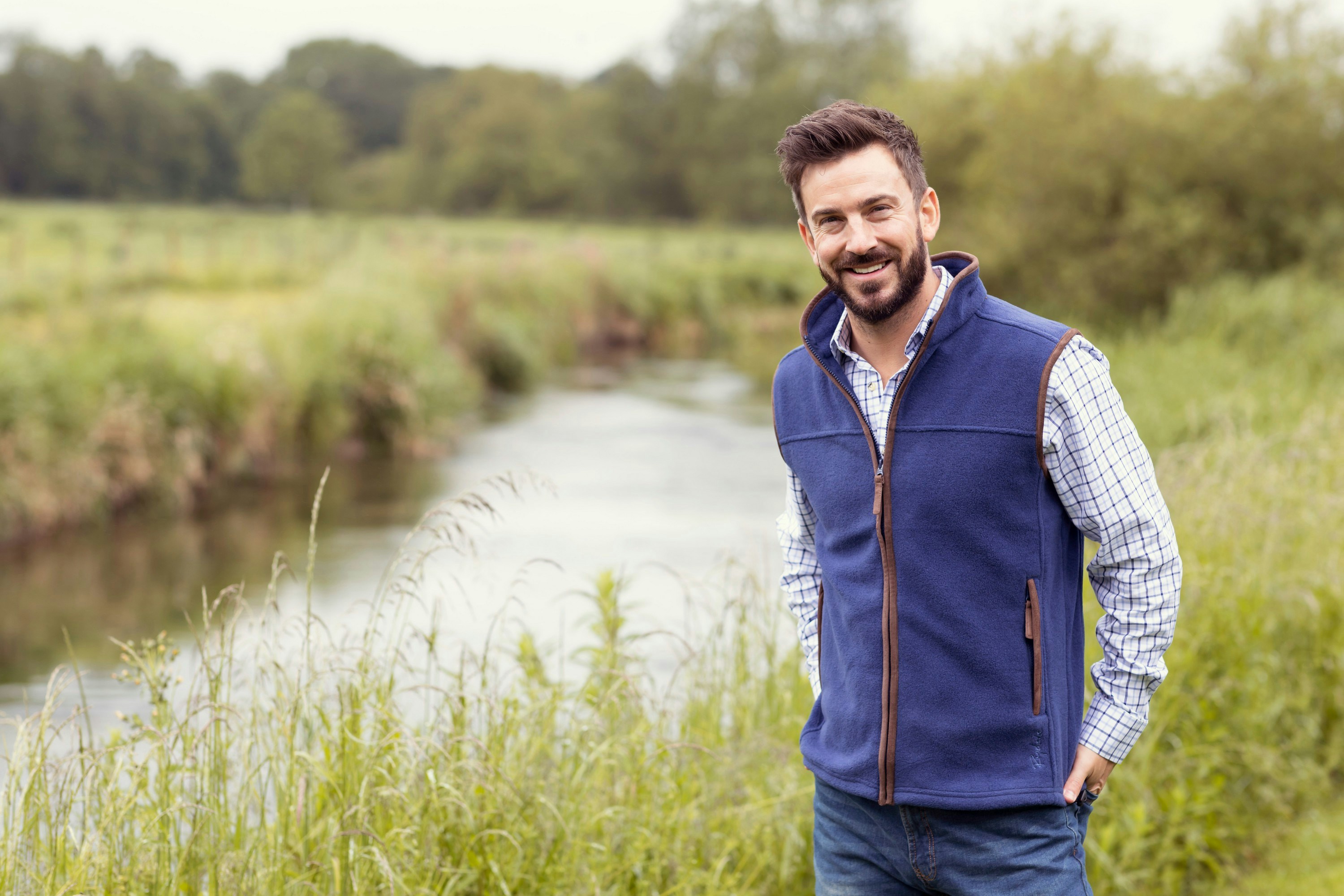 A man standing in a field next to a river photo – Free Man wearing ...
