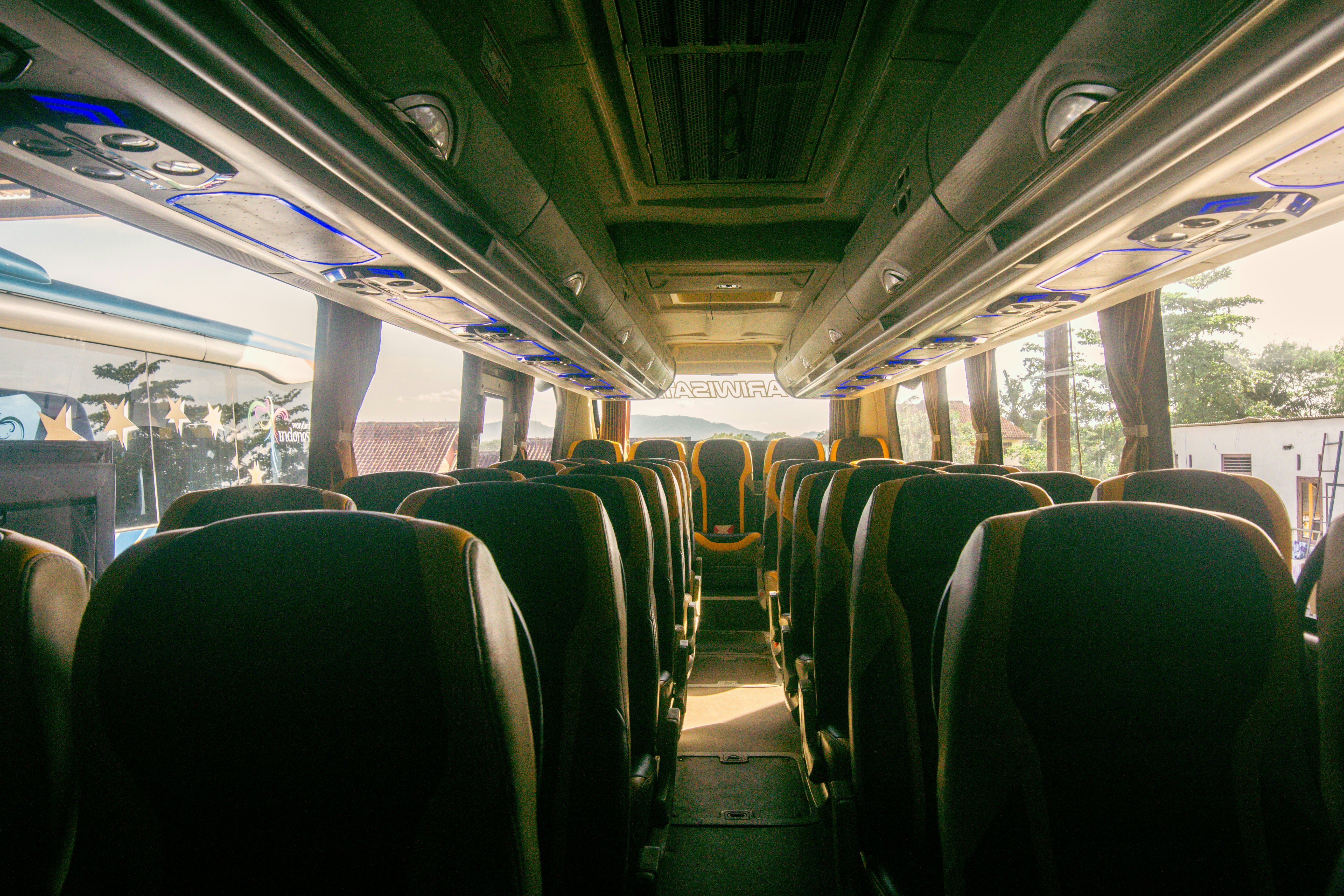 Interior of an empty bus with sunlight streaming in through the windows, casting soft shadows on the seats.