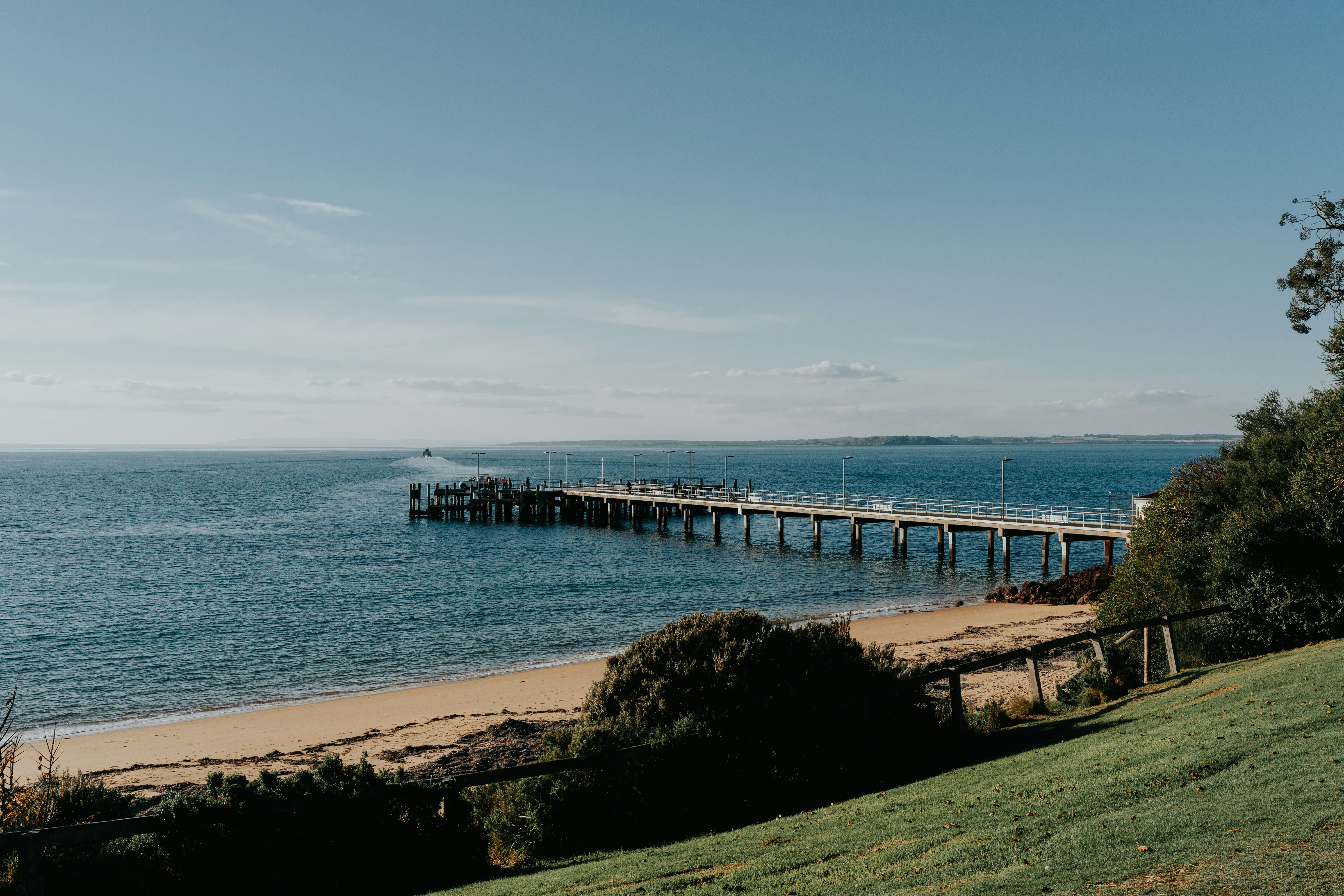 A beach with a pier in the distance photo – Free Cowes beach Image on ...