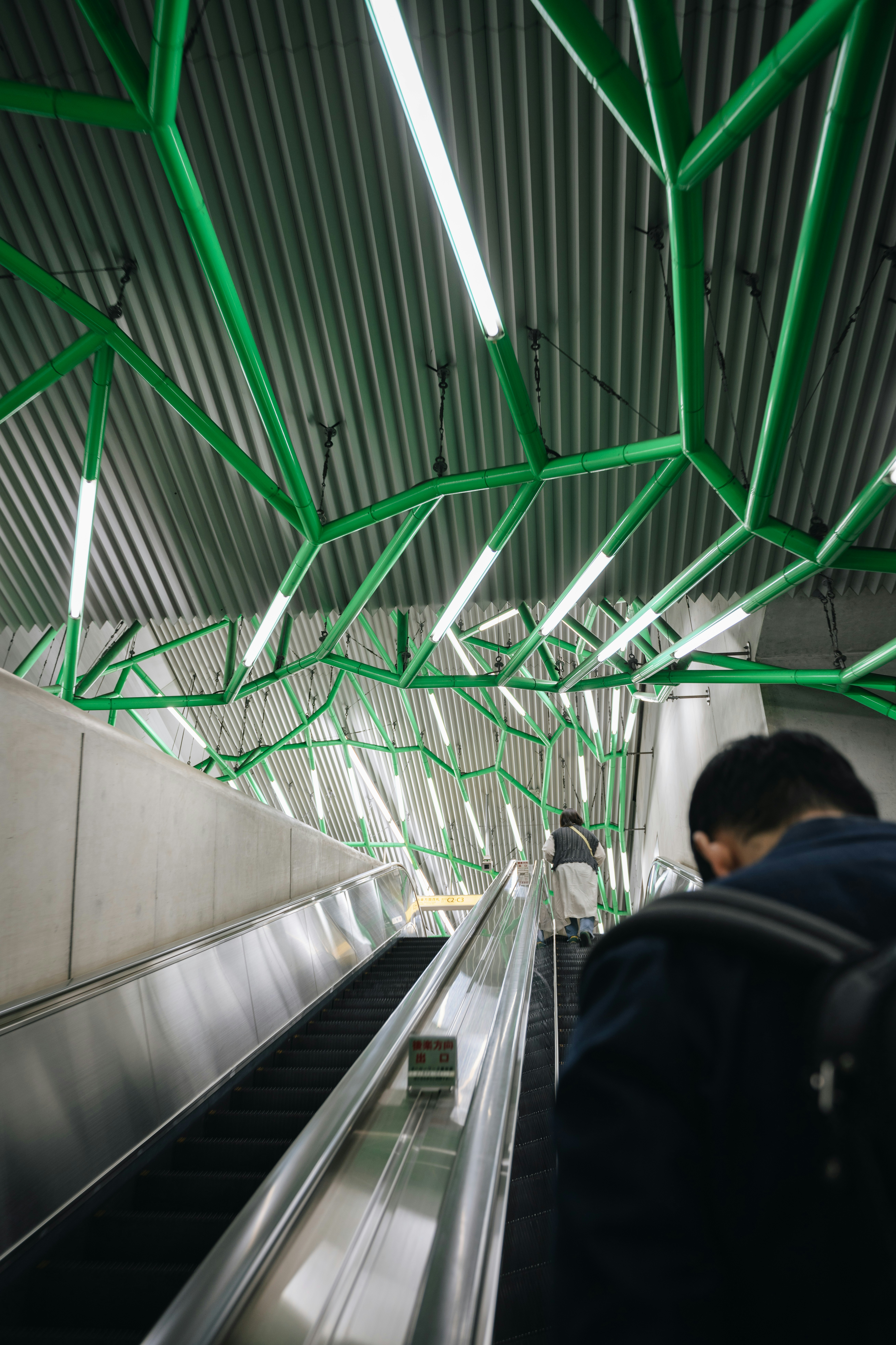 Neon Green Lattice Over an Urban Escalator