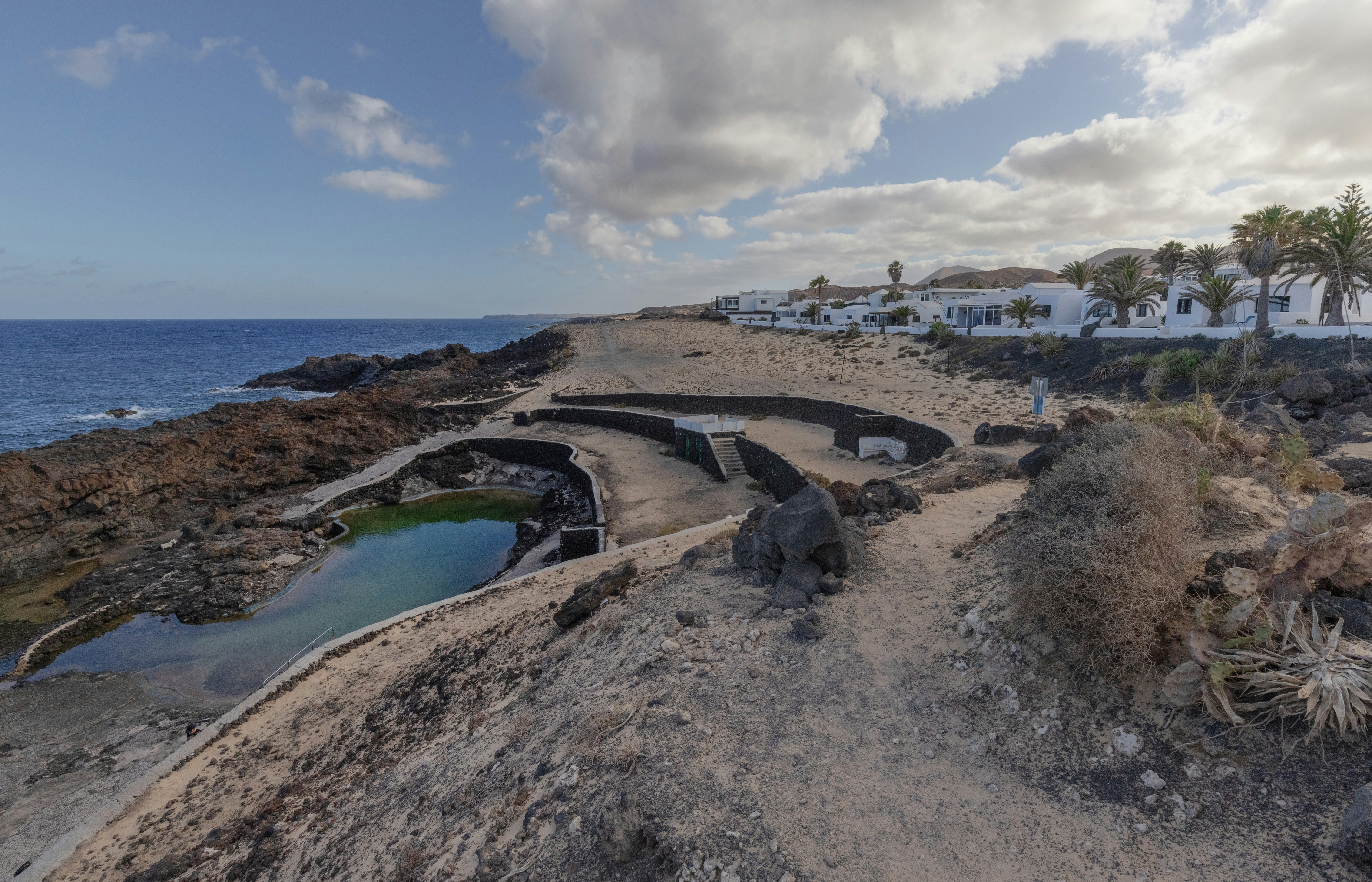 Volcanic Tide Pools Framing a Sunlit Coastal Village