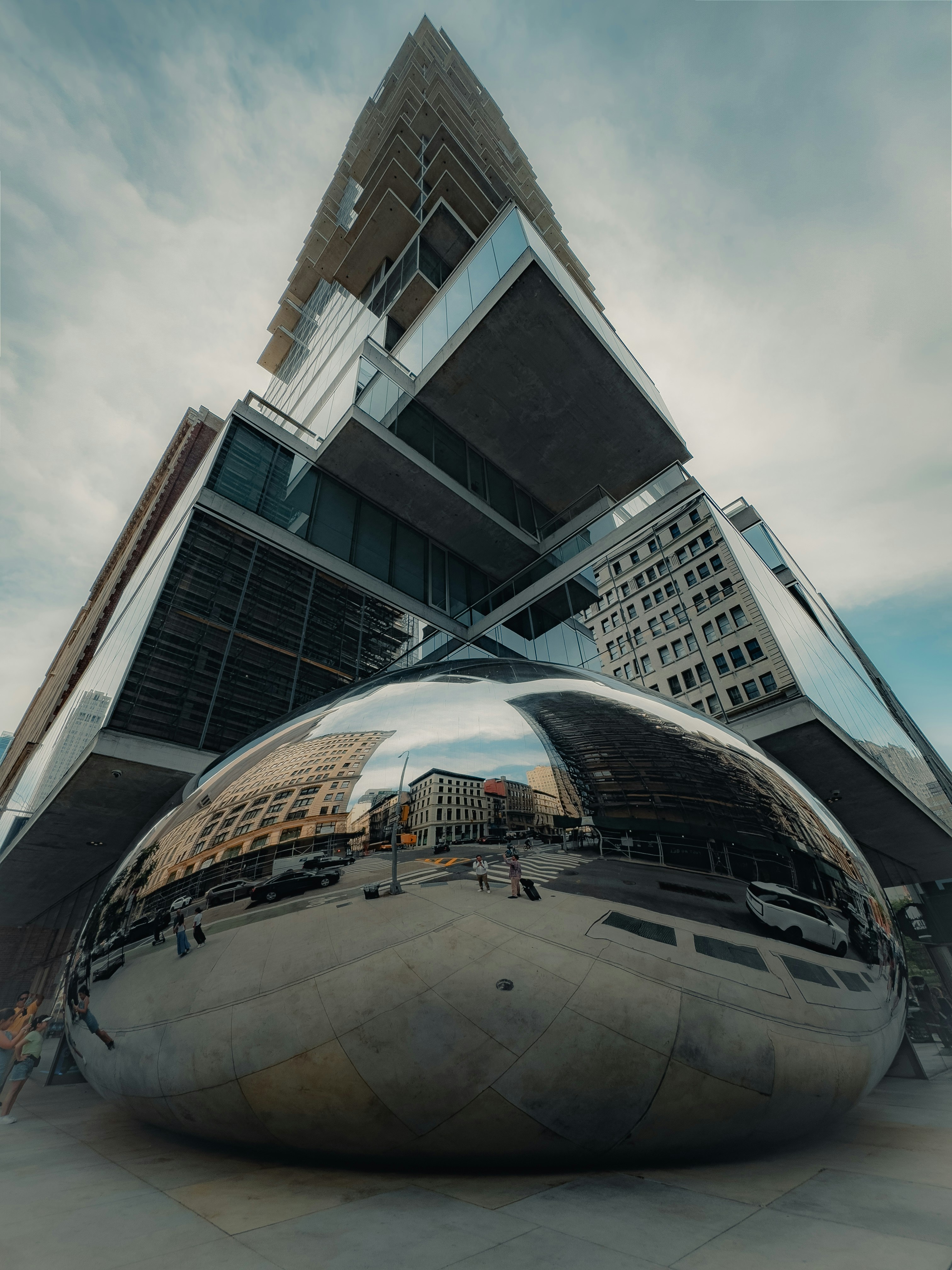 A large metal object sitting in front of a tall building photo – Free ...