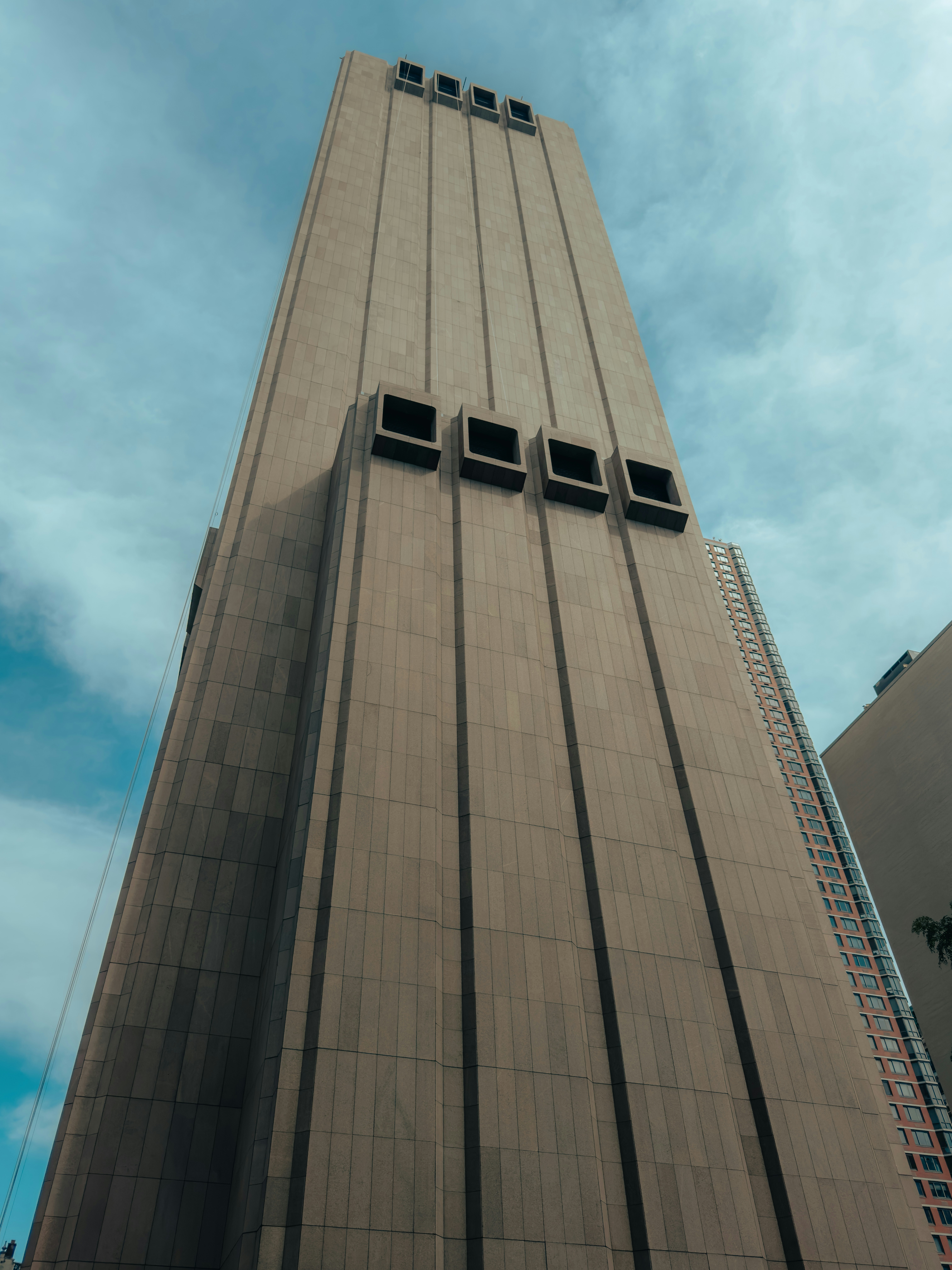 Brutalist Colossus: A Skyward Tower Against a Blue Afternoon