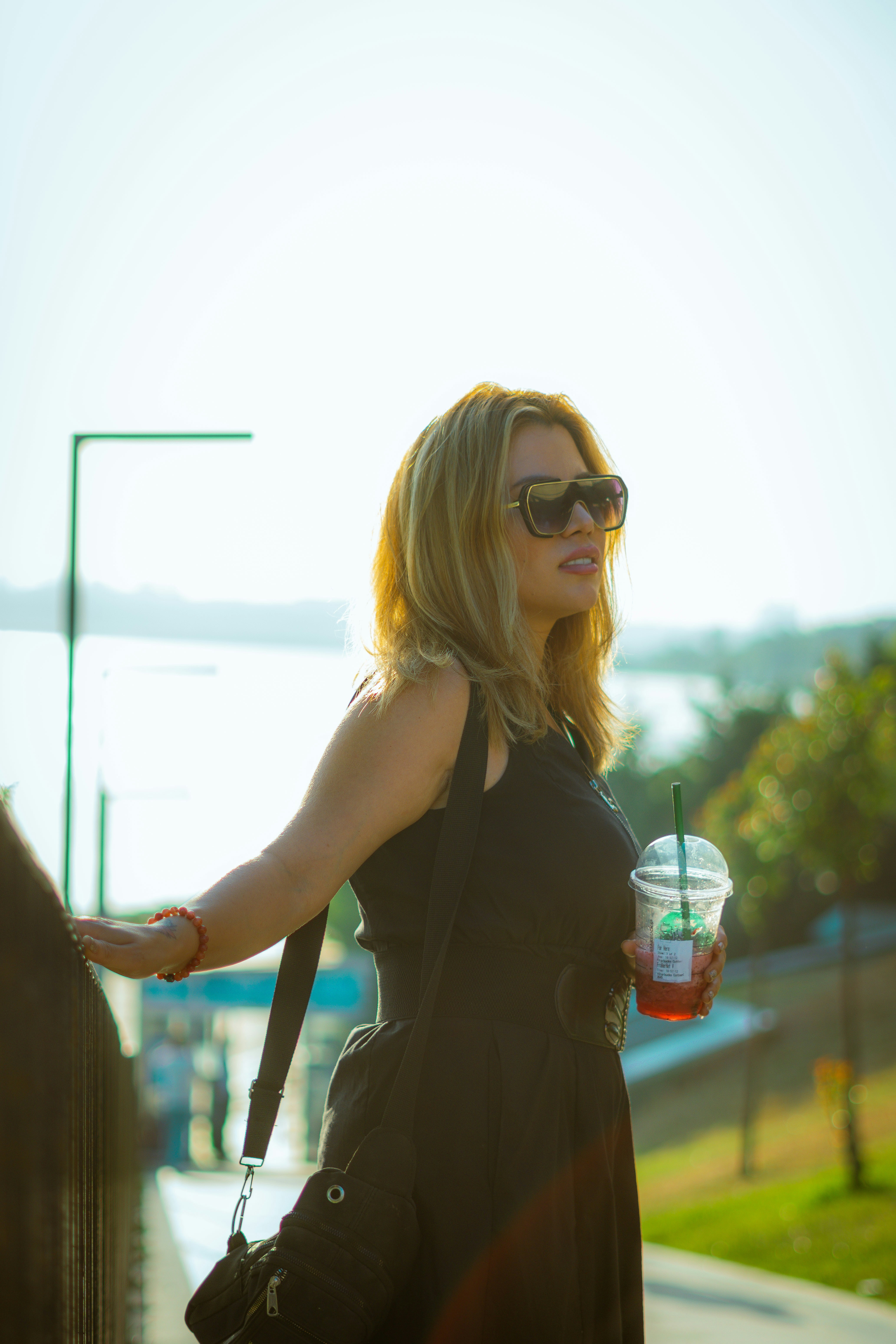 Backlit Waterfront Portrait: A Stylish Moment Along the Sunlit Promenade
