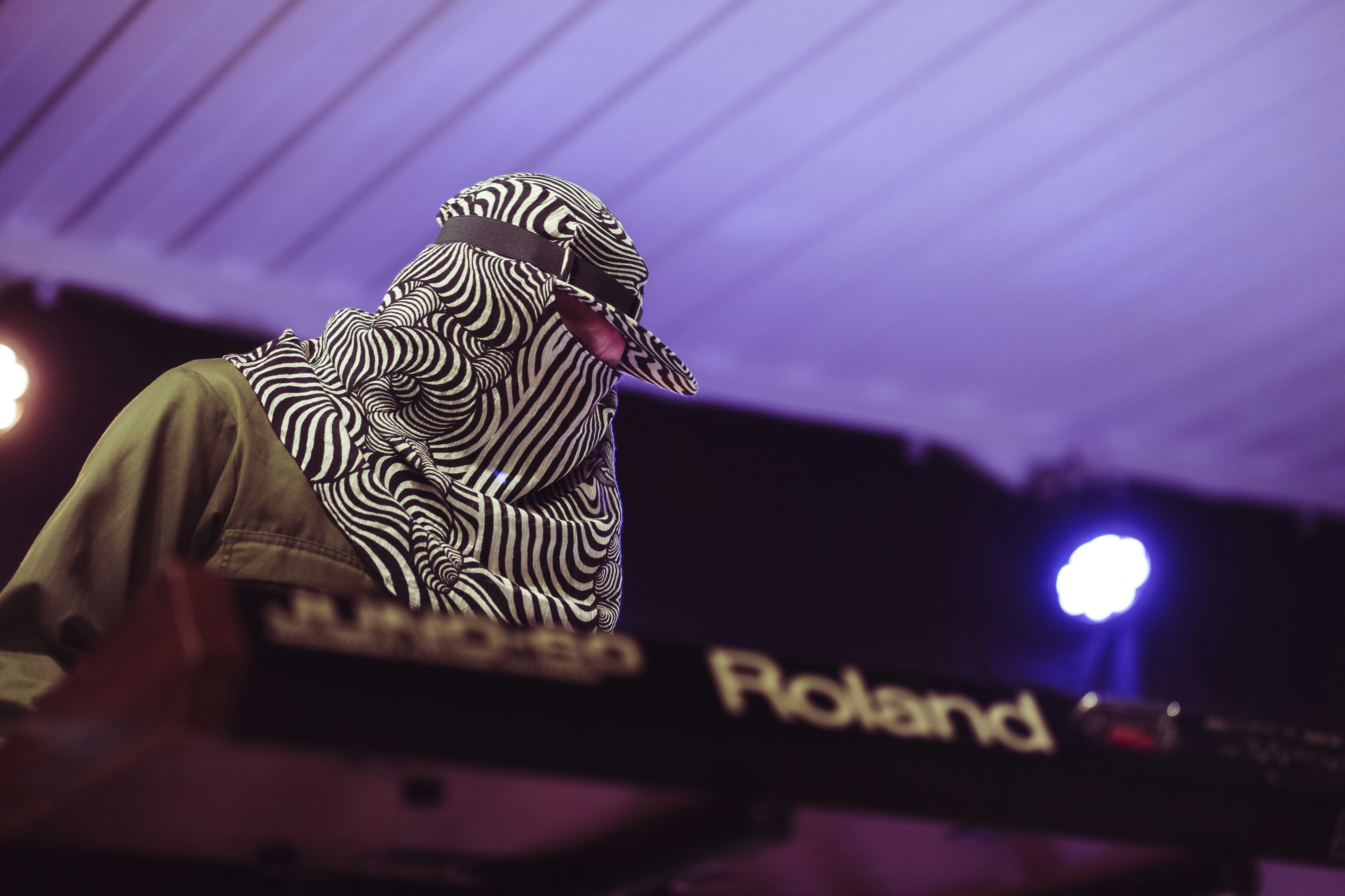 Masked Keyboardist Under Purple Stage Lights