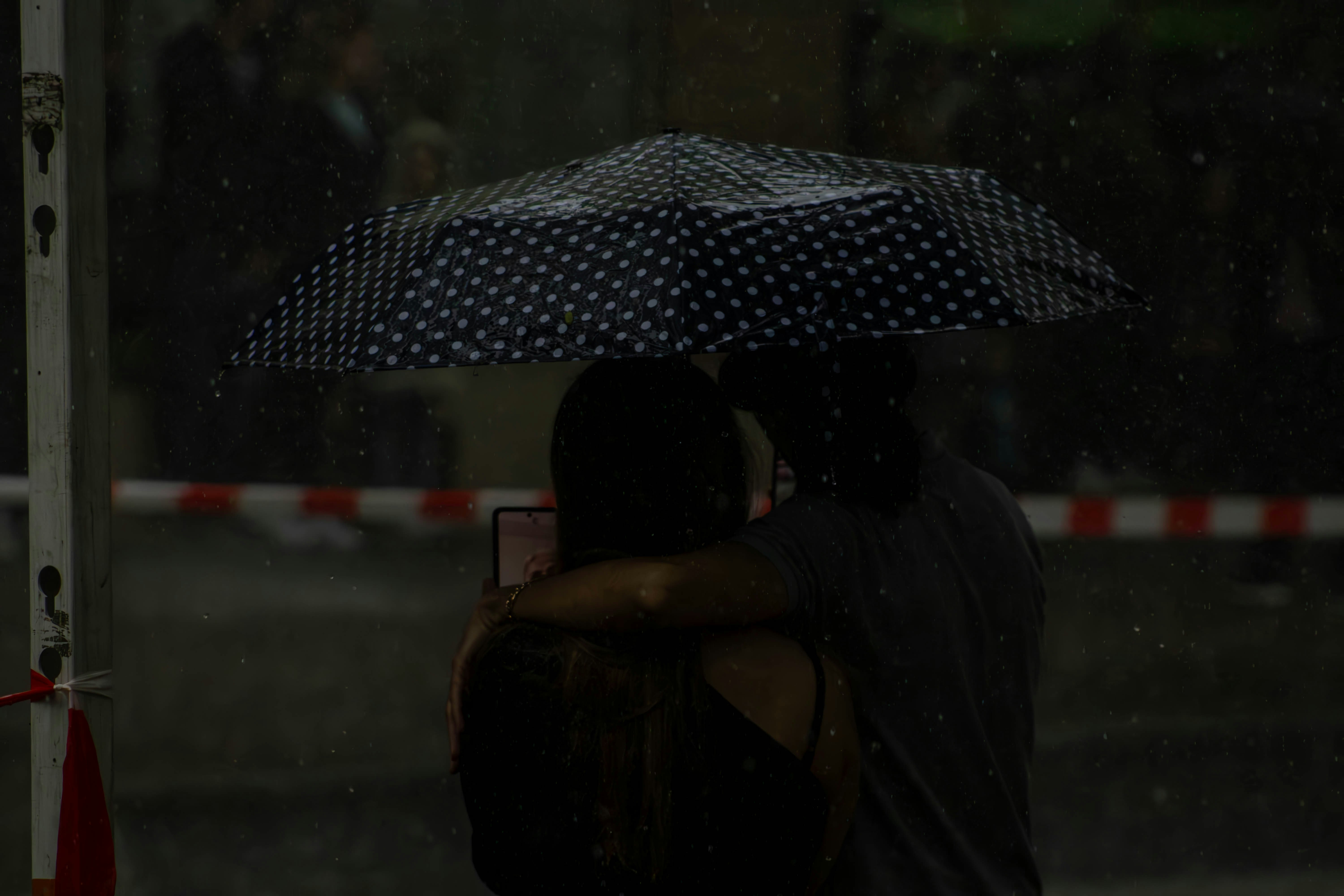 A man and a woman standing under an umbrella in the rain photo – Free ...