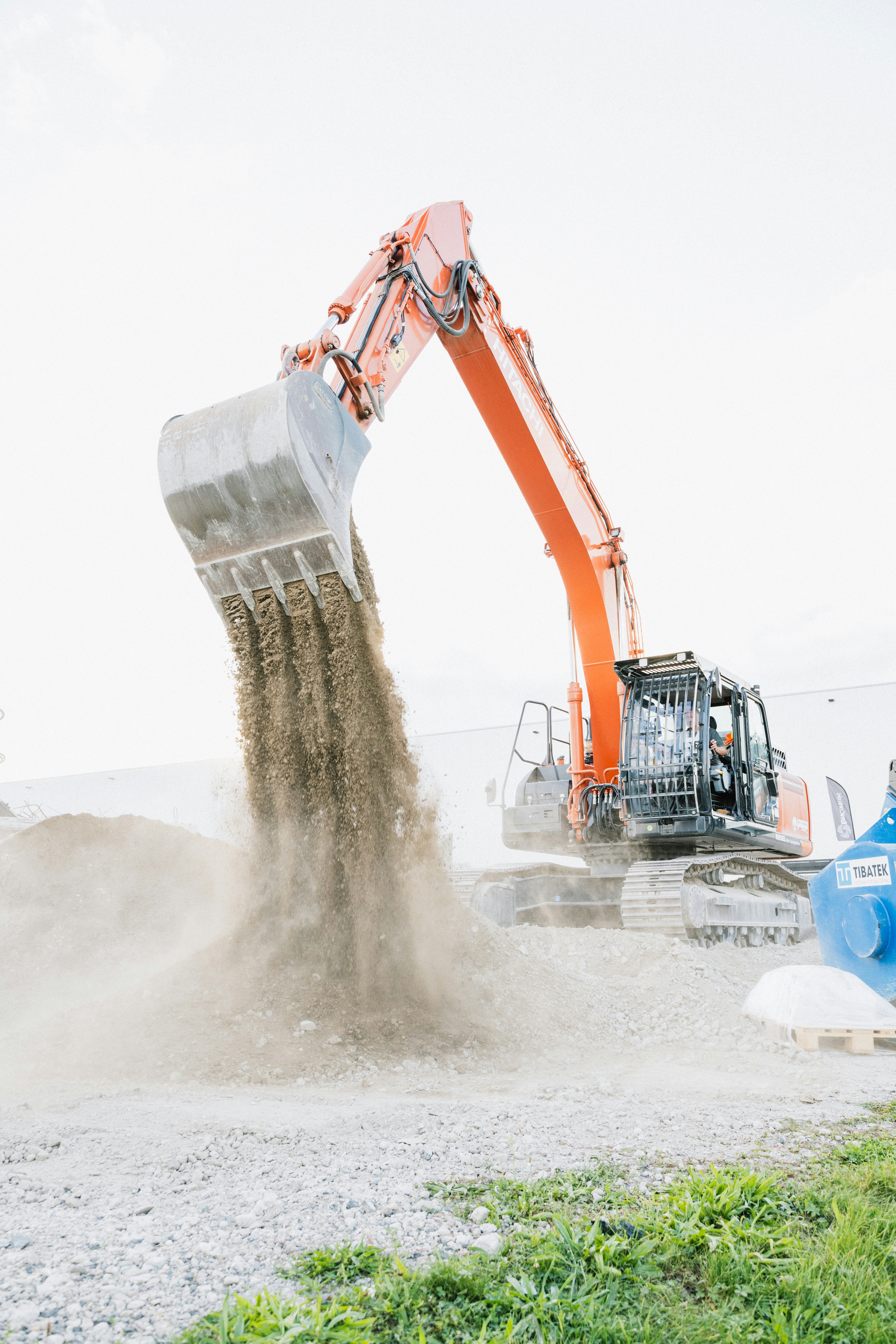 A couple of trucks are dumping dirt on a field photo – Free Ausrüstung ...
