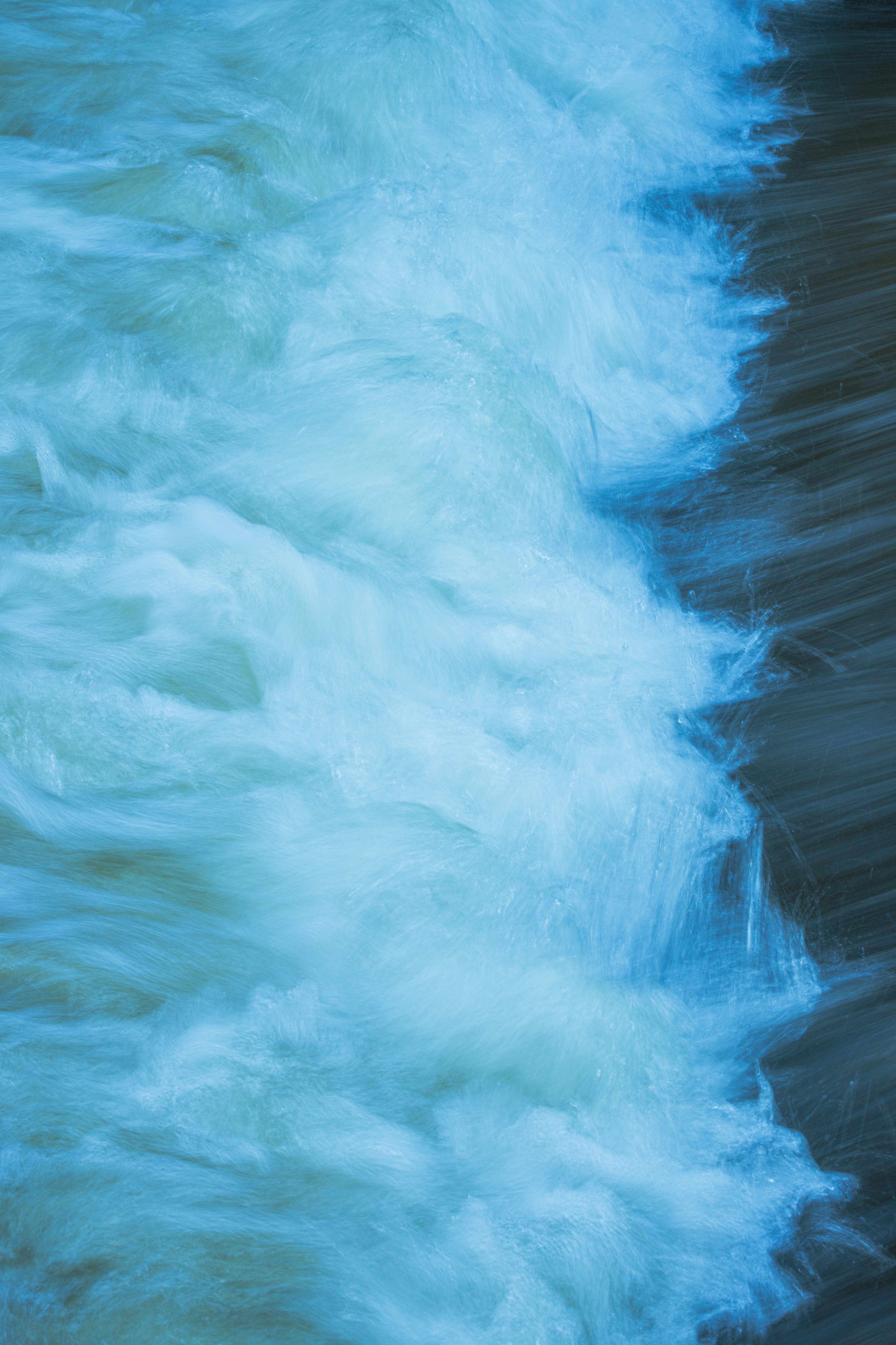 The water is rushing over the black rocks photo – Free Texture Image on ...