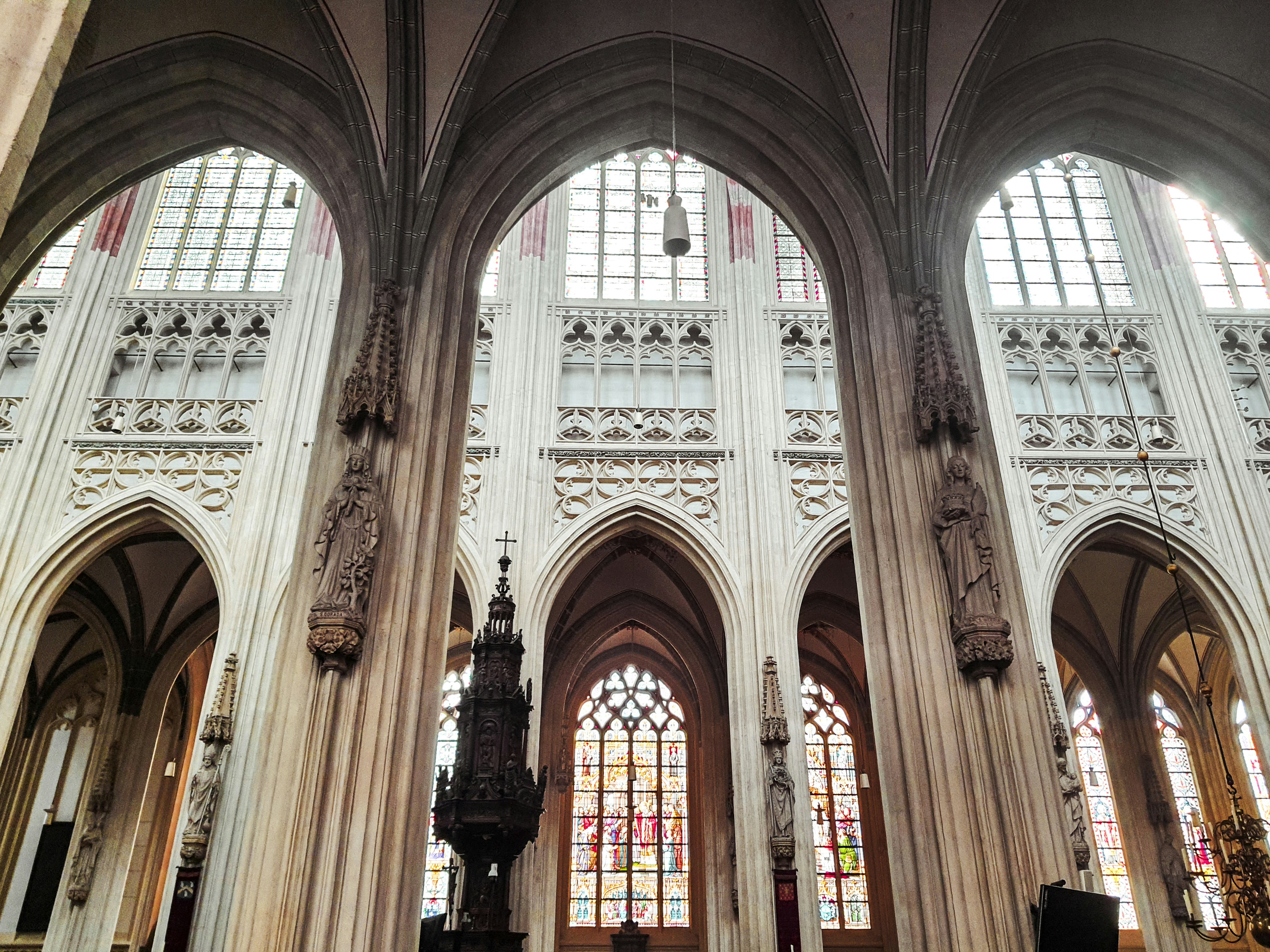 A large cathedral with high vaulted ceilings and stained glass windows ...
