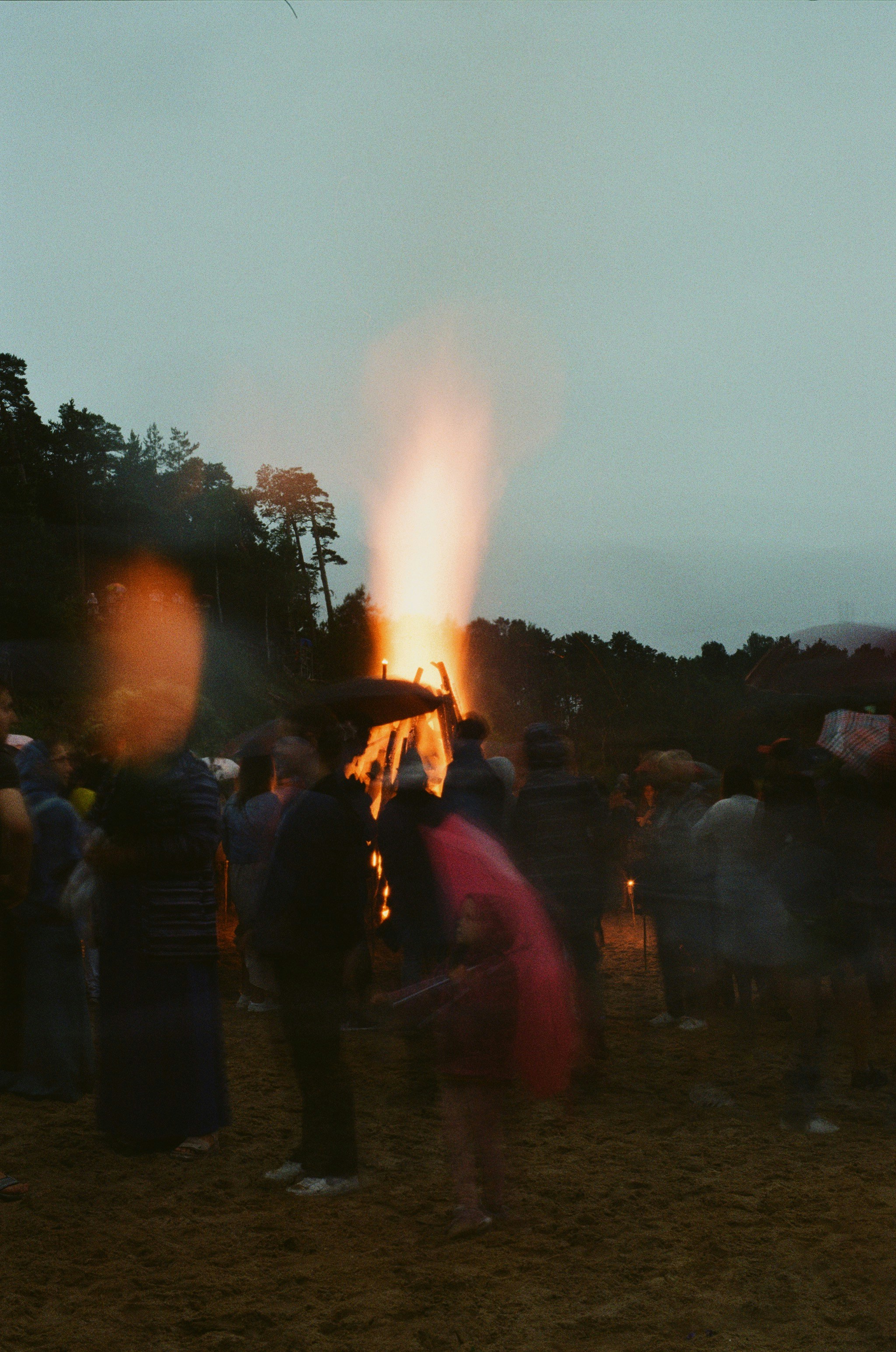 Ember Revelry: Ghostly Silhouettes Circle a Central Bonfire