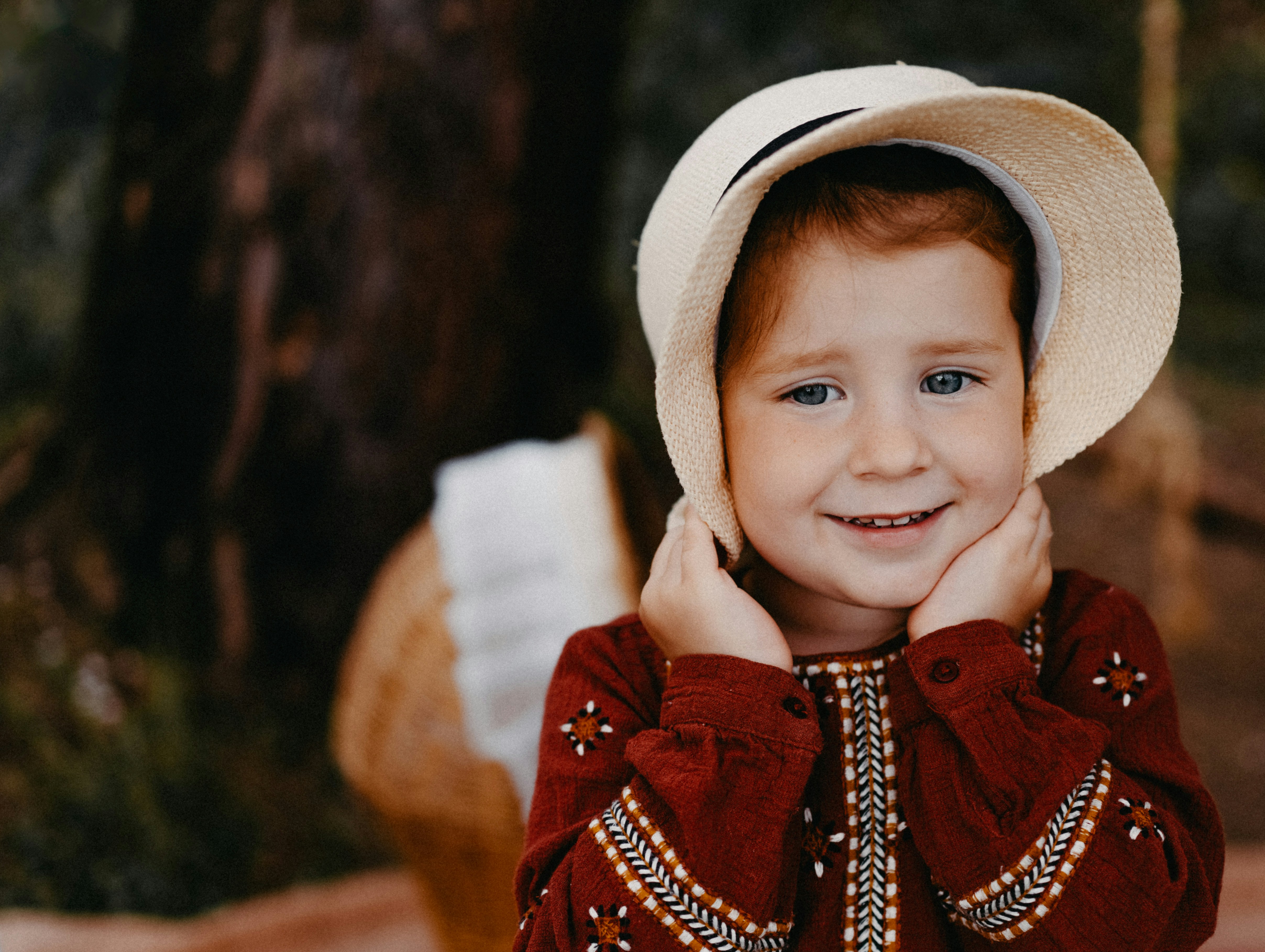 Whimsy Behind the Brim: A Portrait of a Hat-Wearing Child in Warm Light