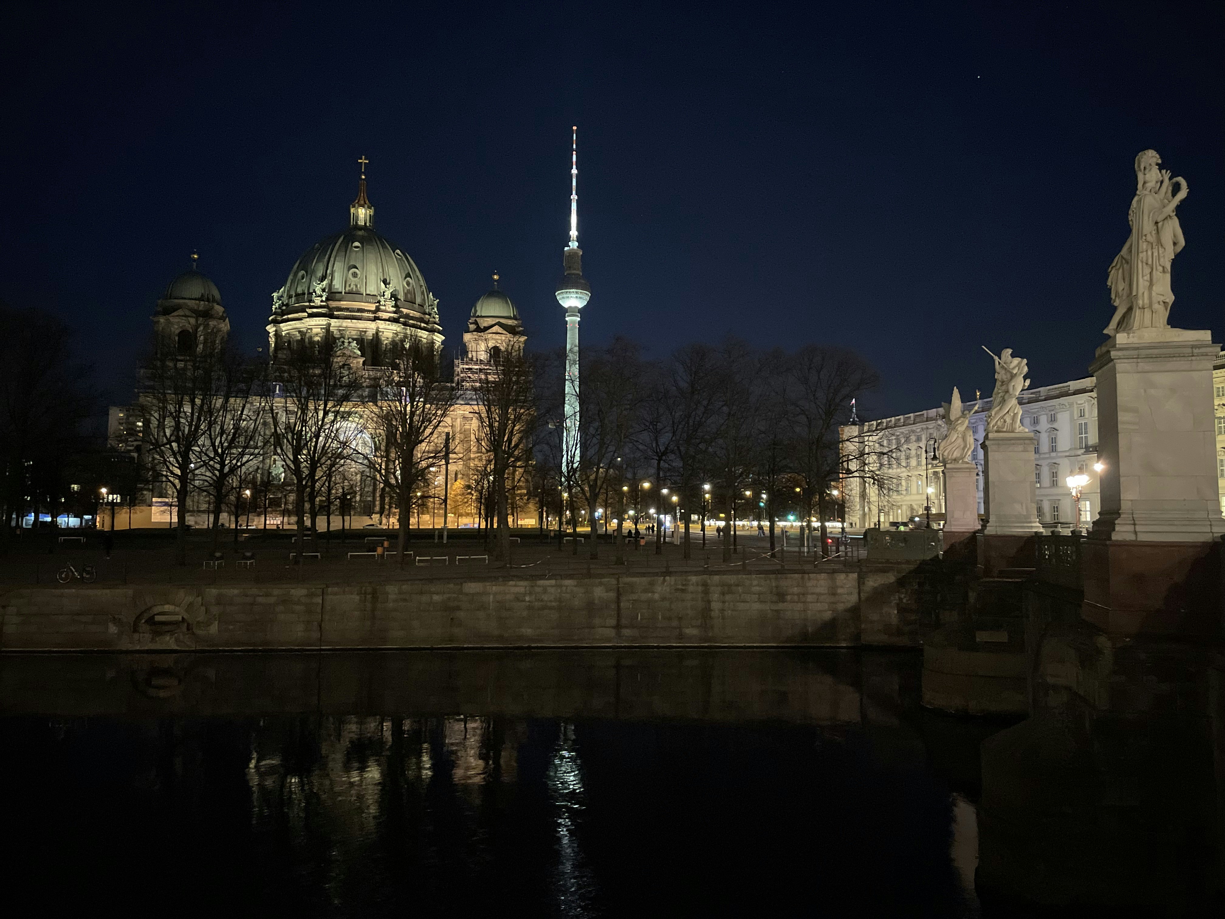 A night view of a large building with a statue in front of it photo ...