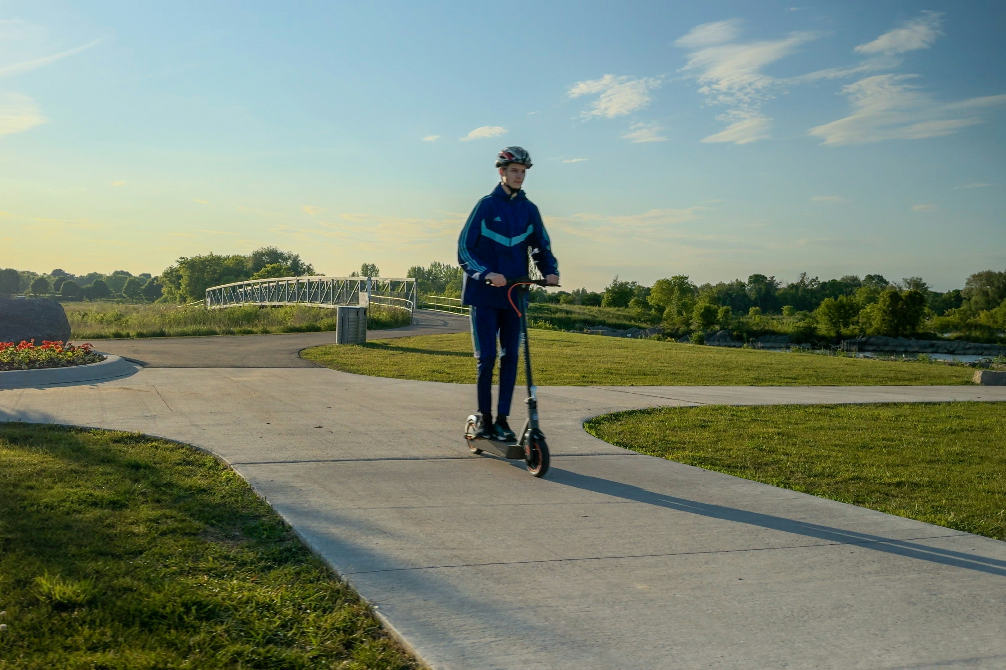 A man riding a scooter down a sidewalk photo – Free S2 max Image on ...