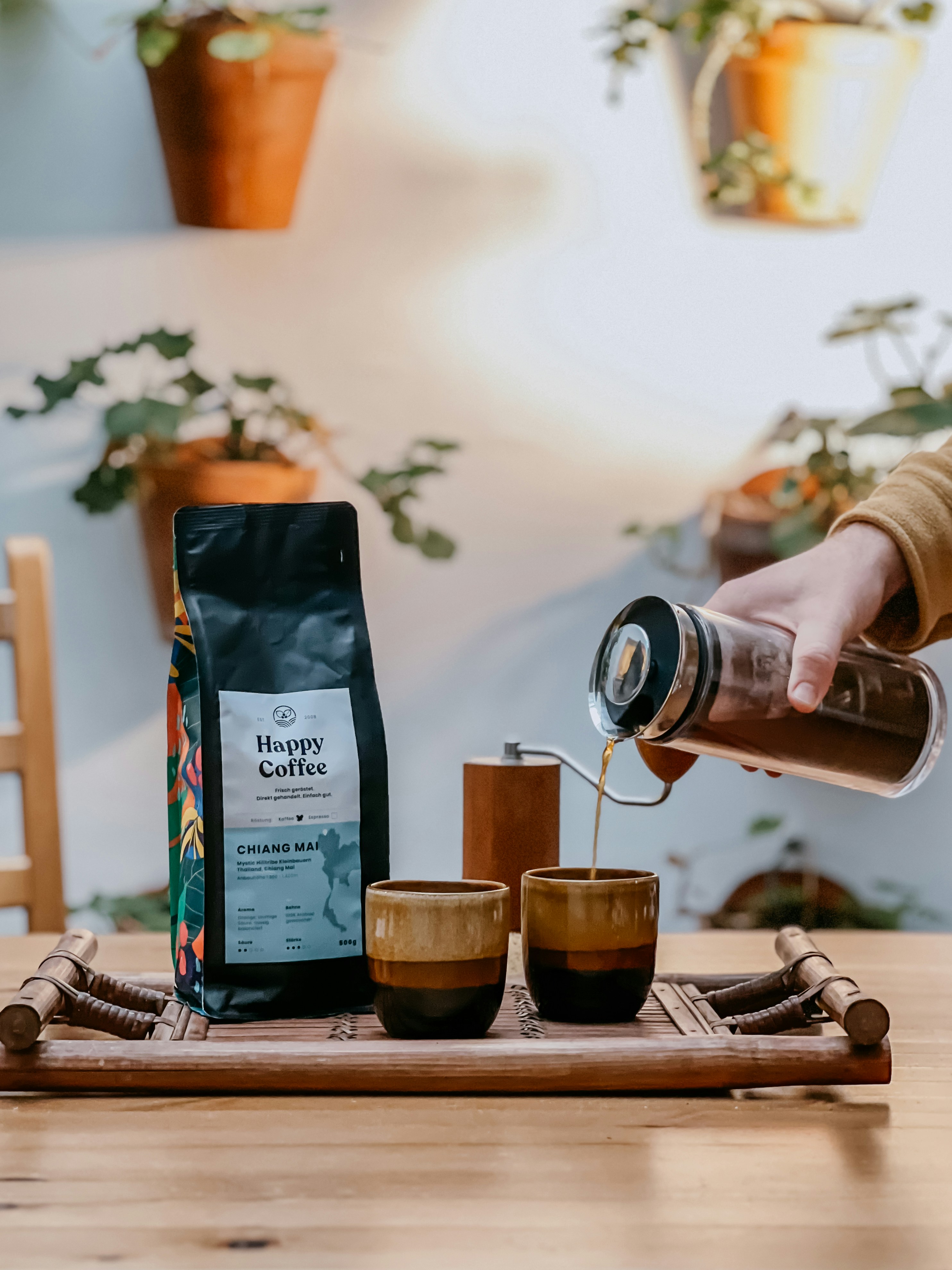 Pouring warmth into two ceramic cups: a plant-framed coffee ritual