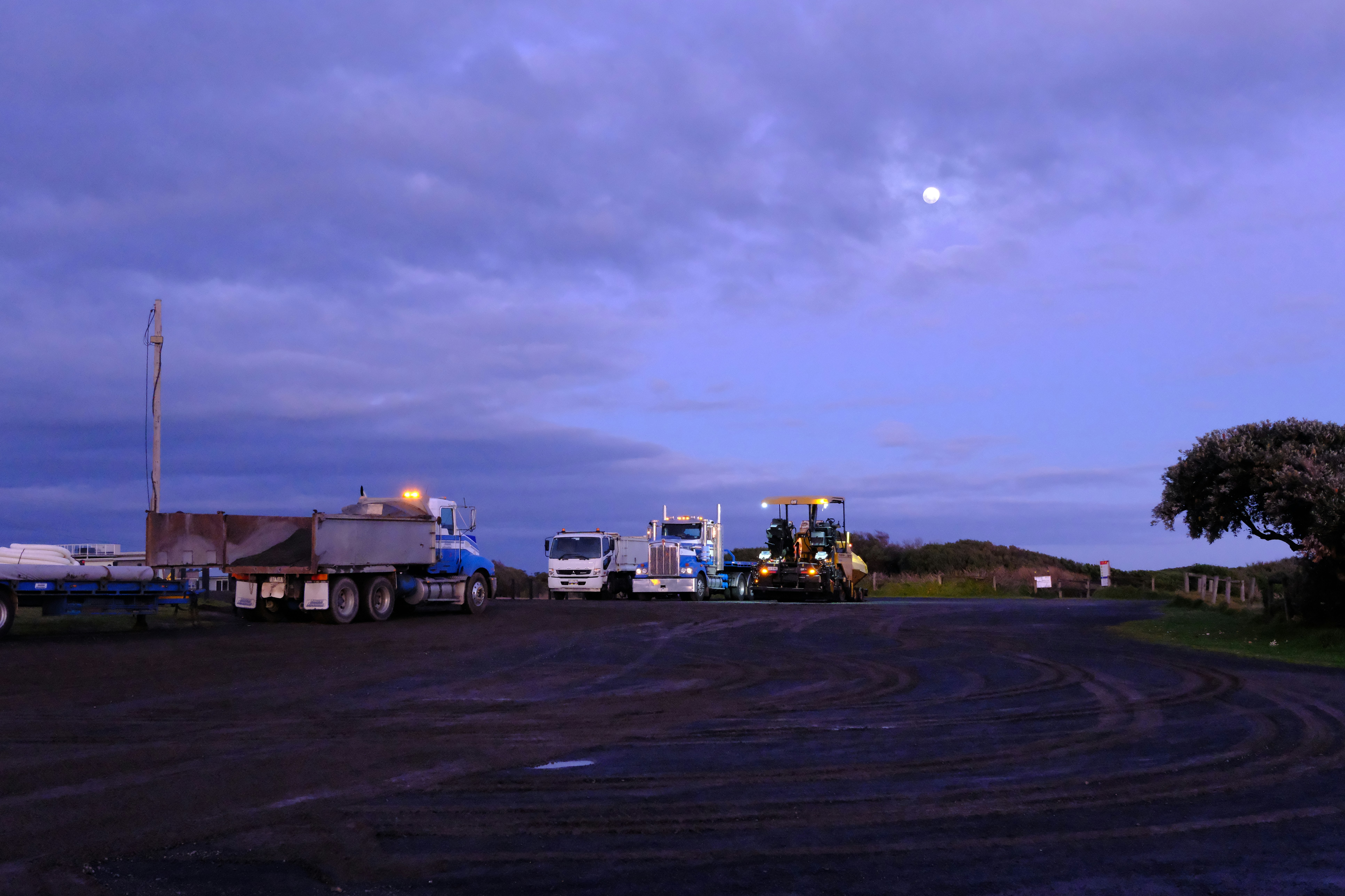 Dusk Yard Convoy Beneath a Pale Moon