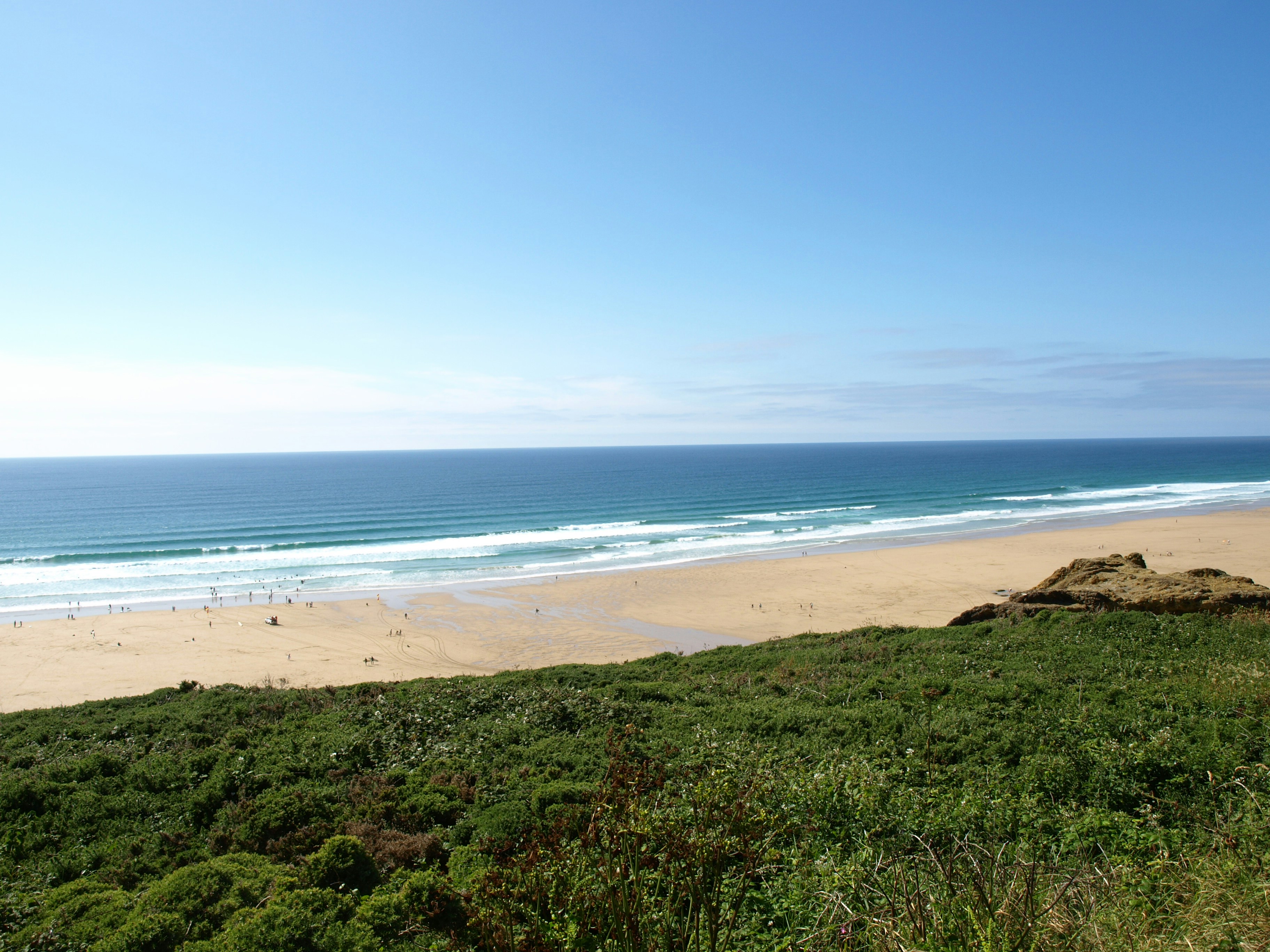 A view of a beach and ocean from a hill photo – Free Watergate bay ...