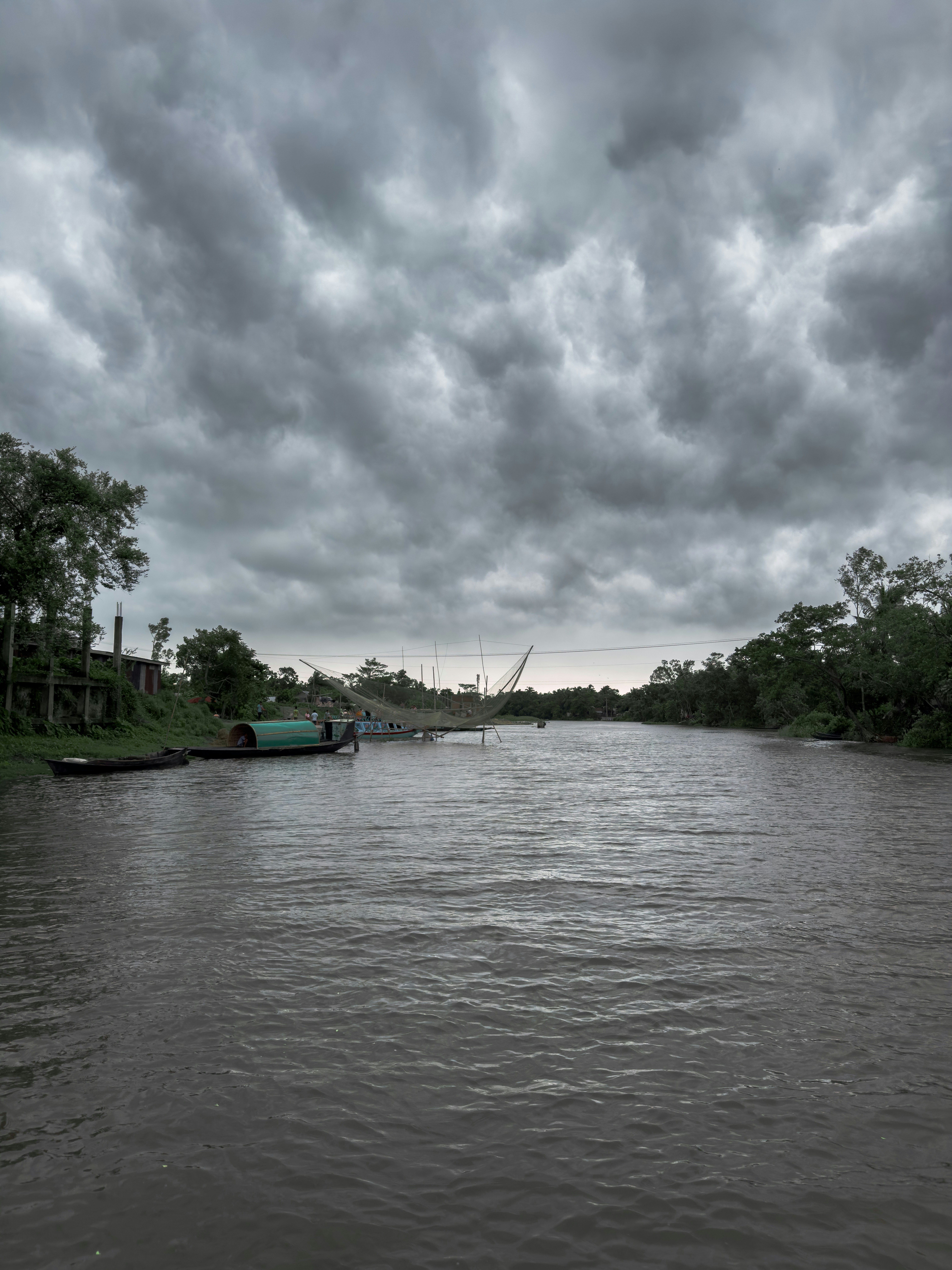 Moody River Portrait: Docked Boats Beneath Leaden Clouds