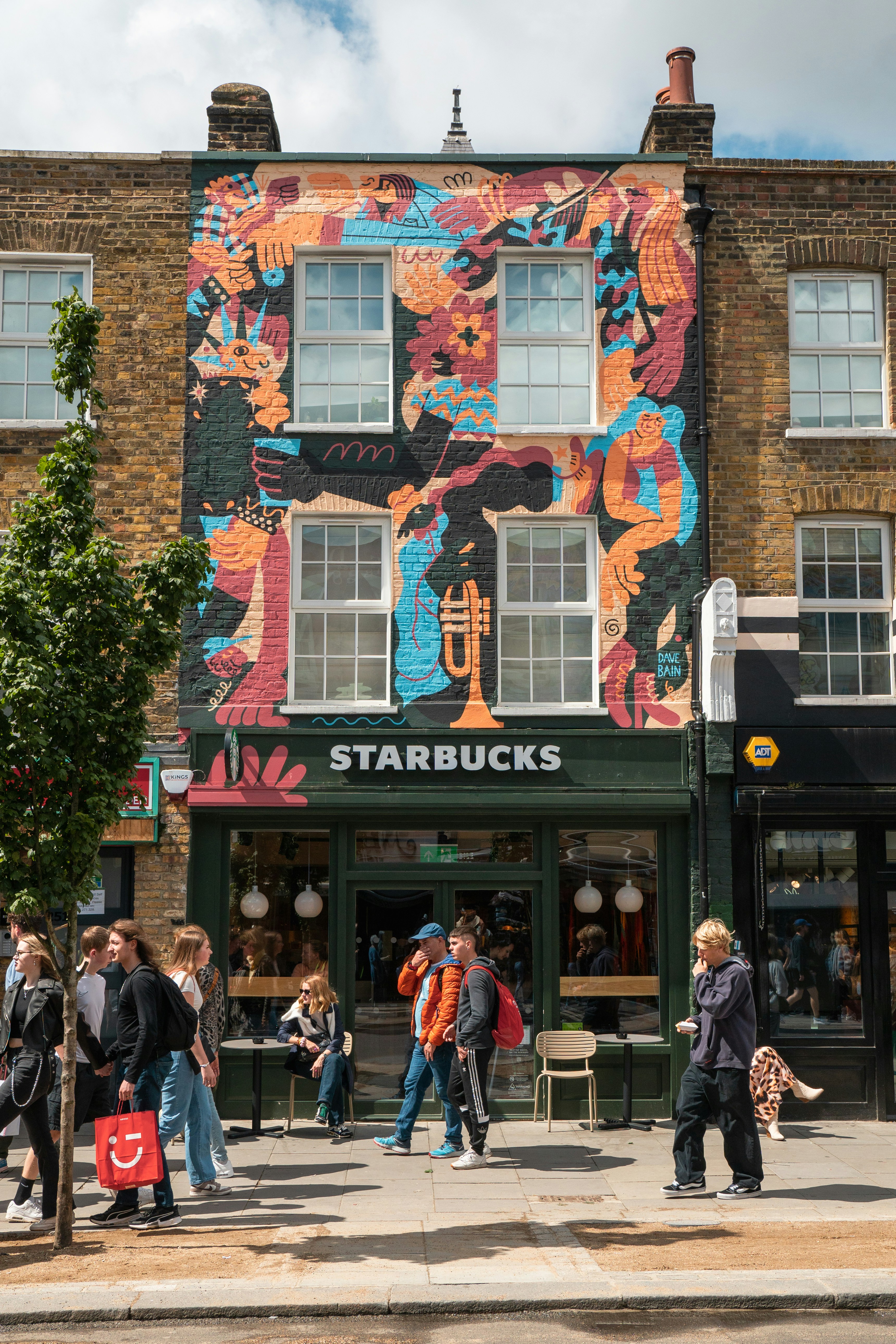 Urban Mosaic Over Starbucks: Colorful Murals Framing a Busy Street Corner
