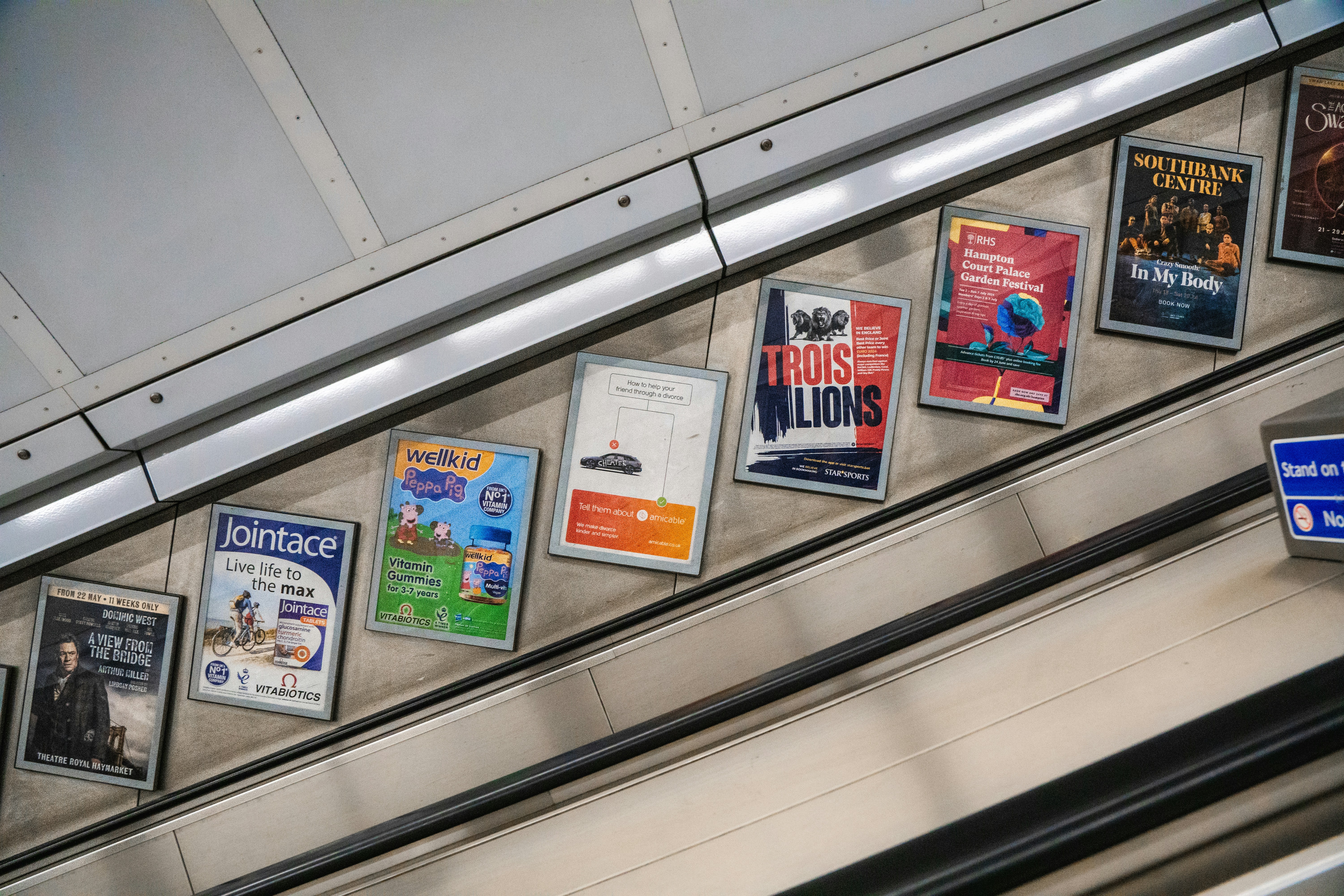 Escalator Gallery: Posters Align in a Diagonal Corridor
