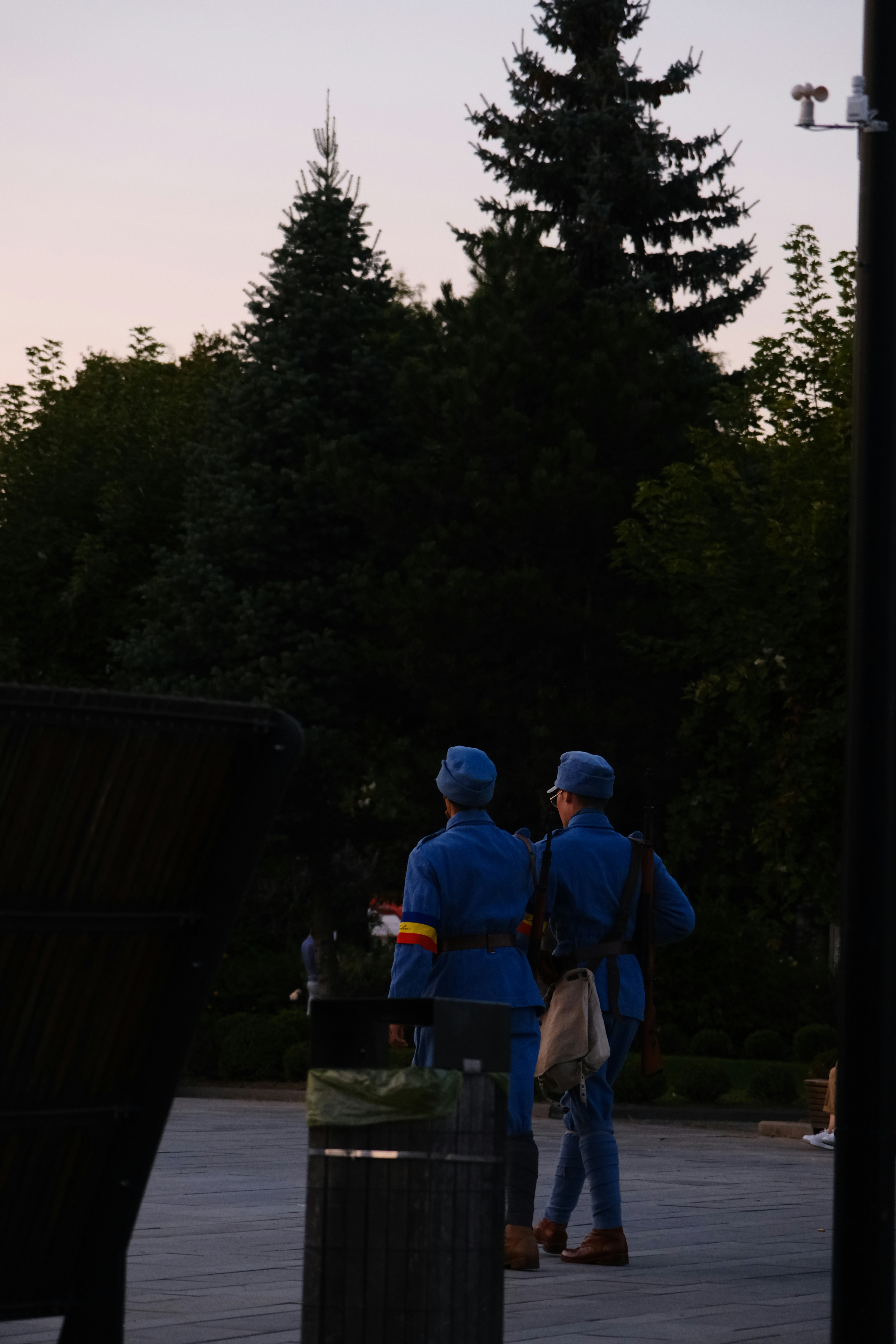 Twilight in Blue: Two Guards Move Through a Quiet Plaza