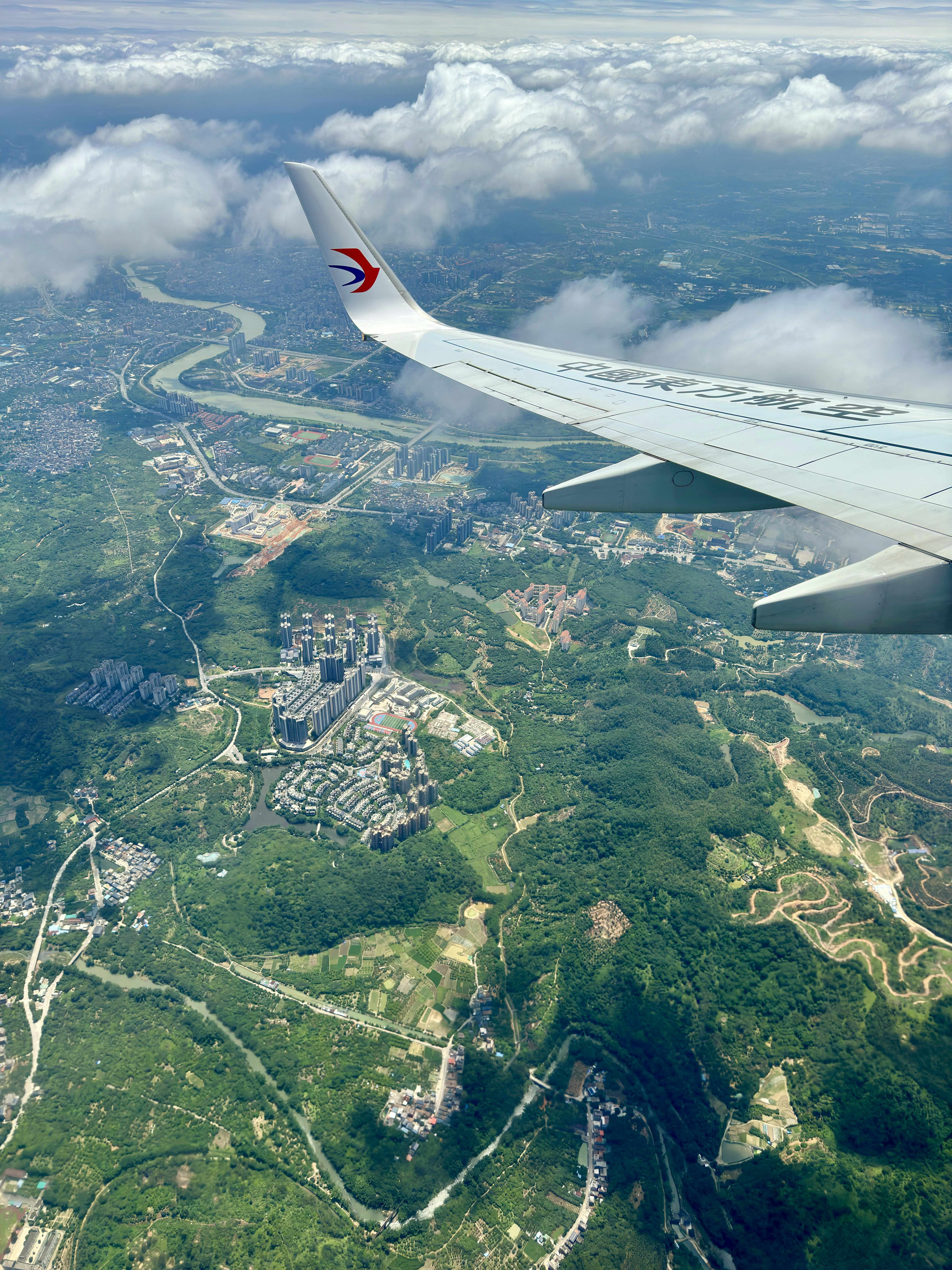 River of Green: Aerial View from the Wing Over a Jade Landscape